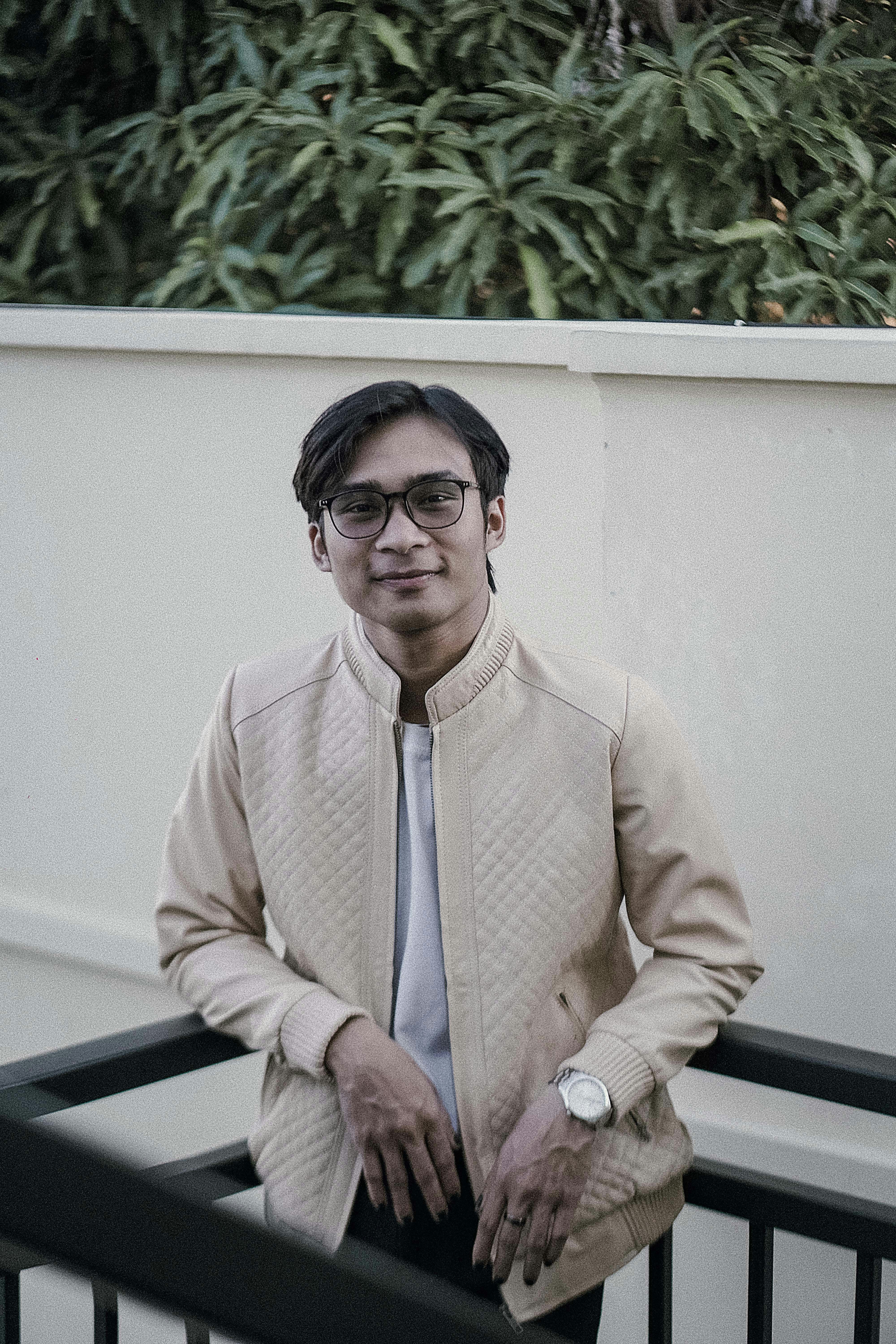 A man in a jacket and tie standing on a balcony photo – Free Garut ...
