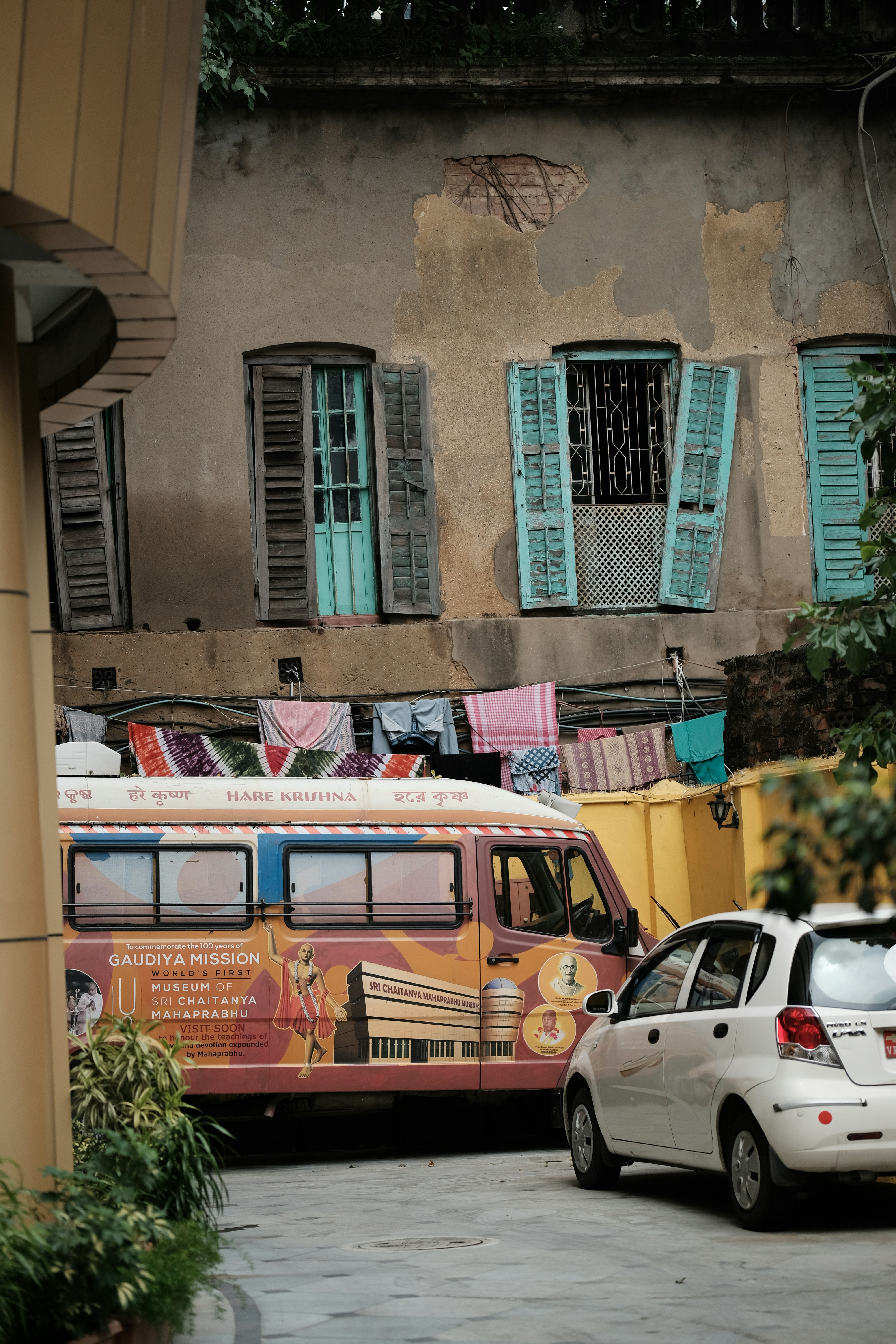 Colorful Street Bus Under Weathered Balconies