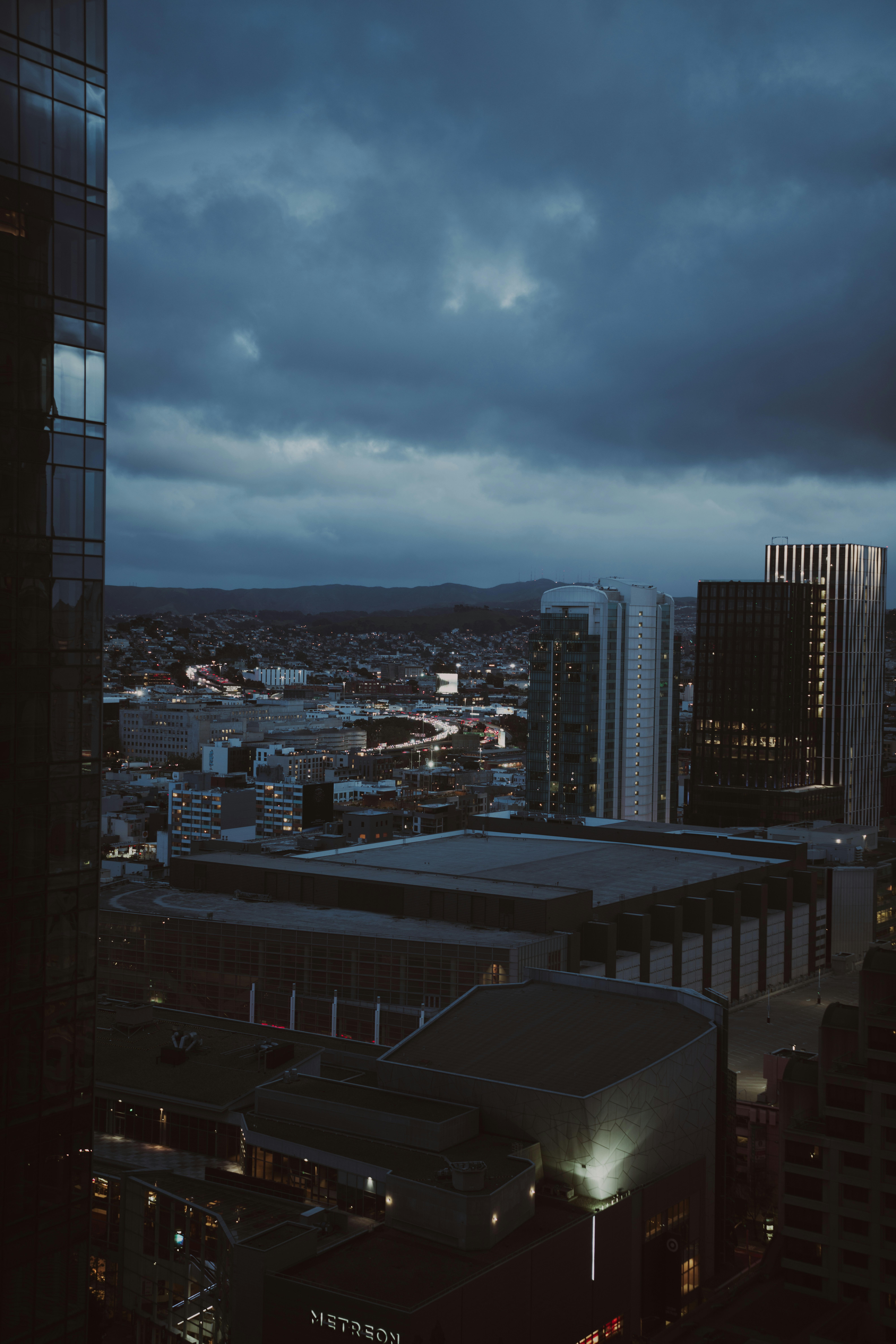 Dusk Over Glass and Steel: A Quiet Skyline Under Looming Clouds