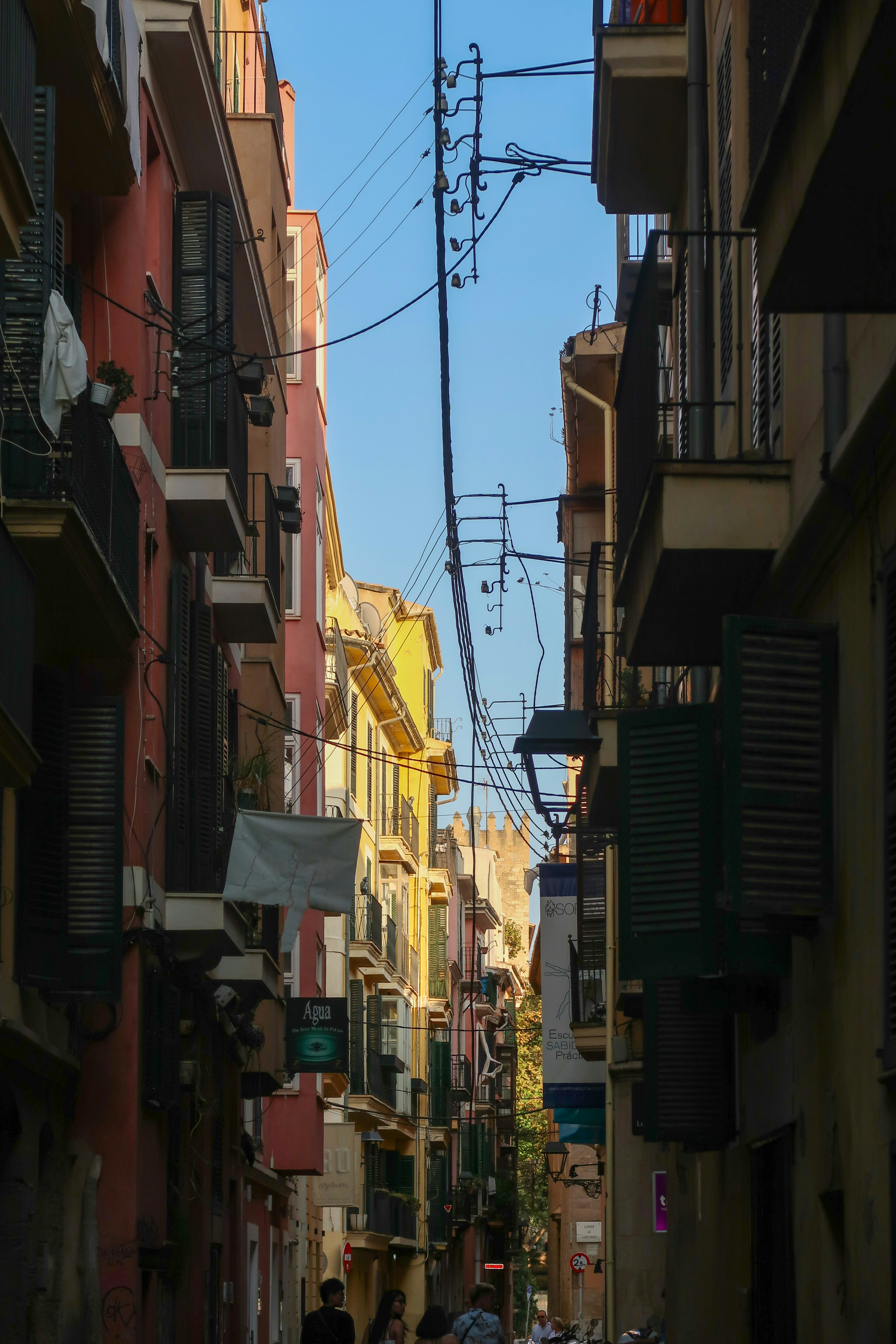 A narrow city street with people walking down it photo – Free City ...