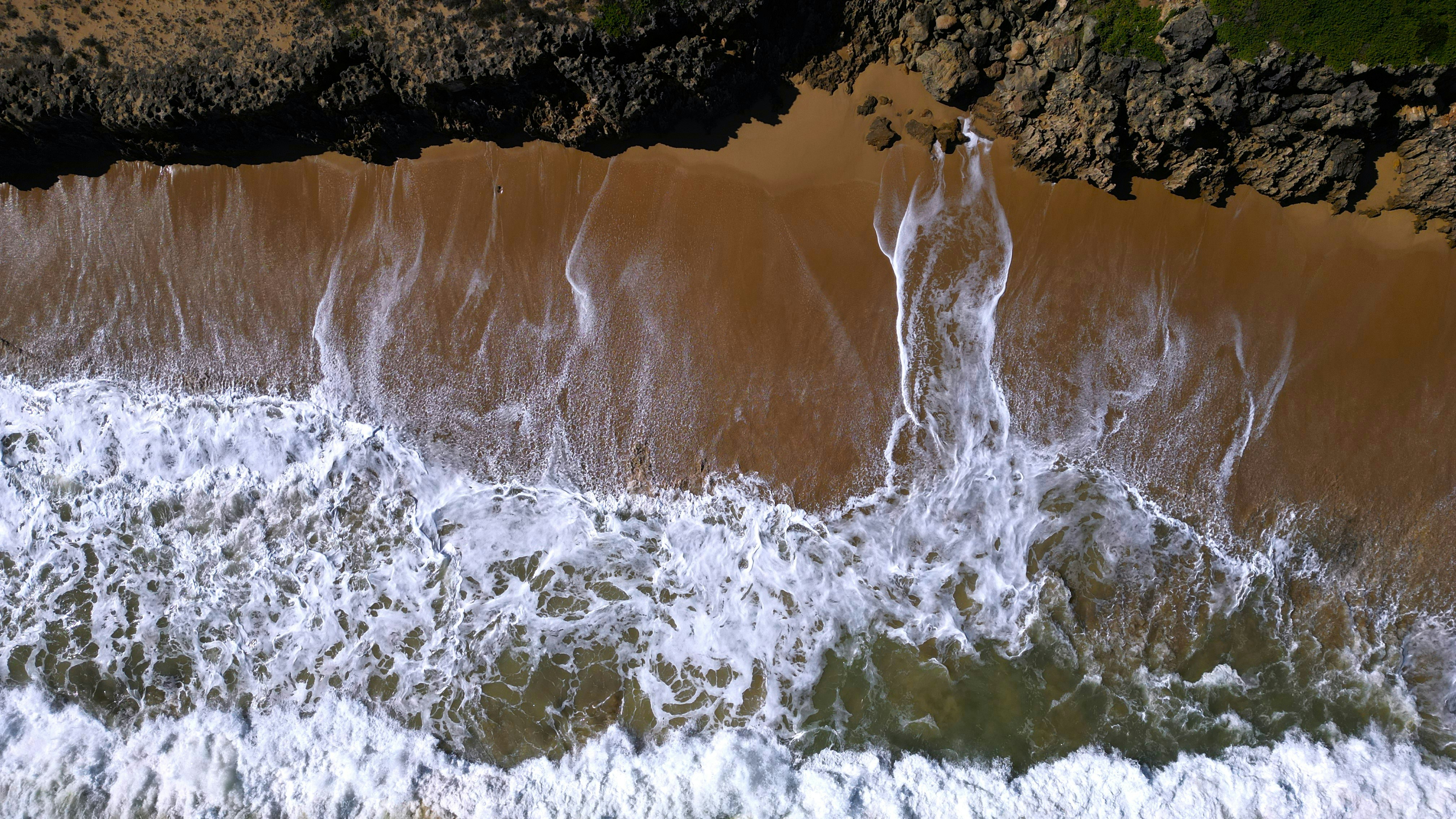 Foam Ribbon at the Edge: Aerial Study of a Rocky Coastal Wake