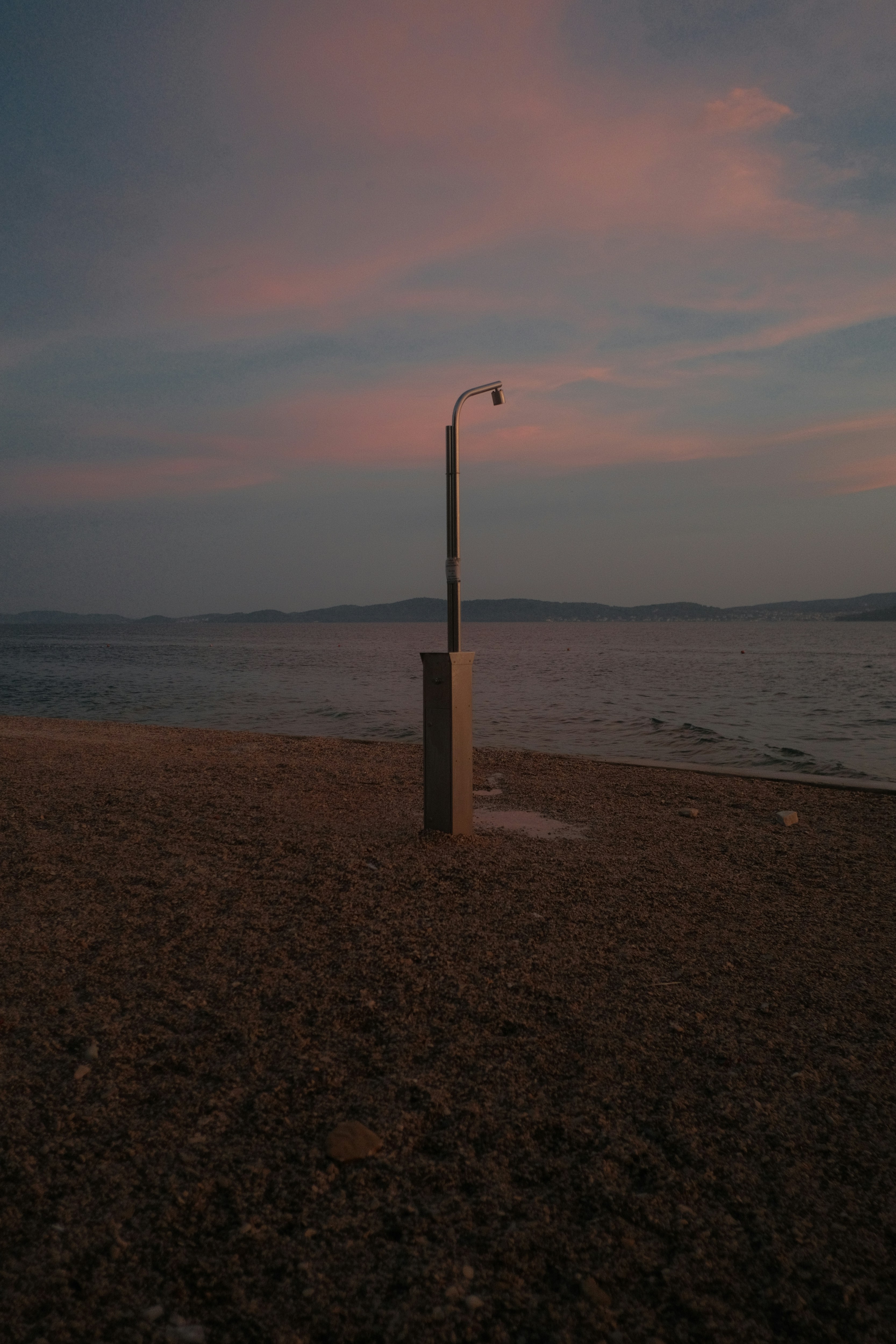 A street light sitting on top of a sandy beach photo – Free Zadar Image ...