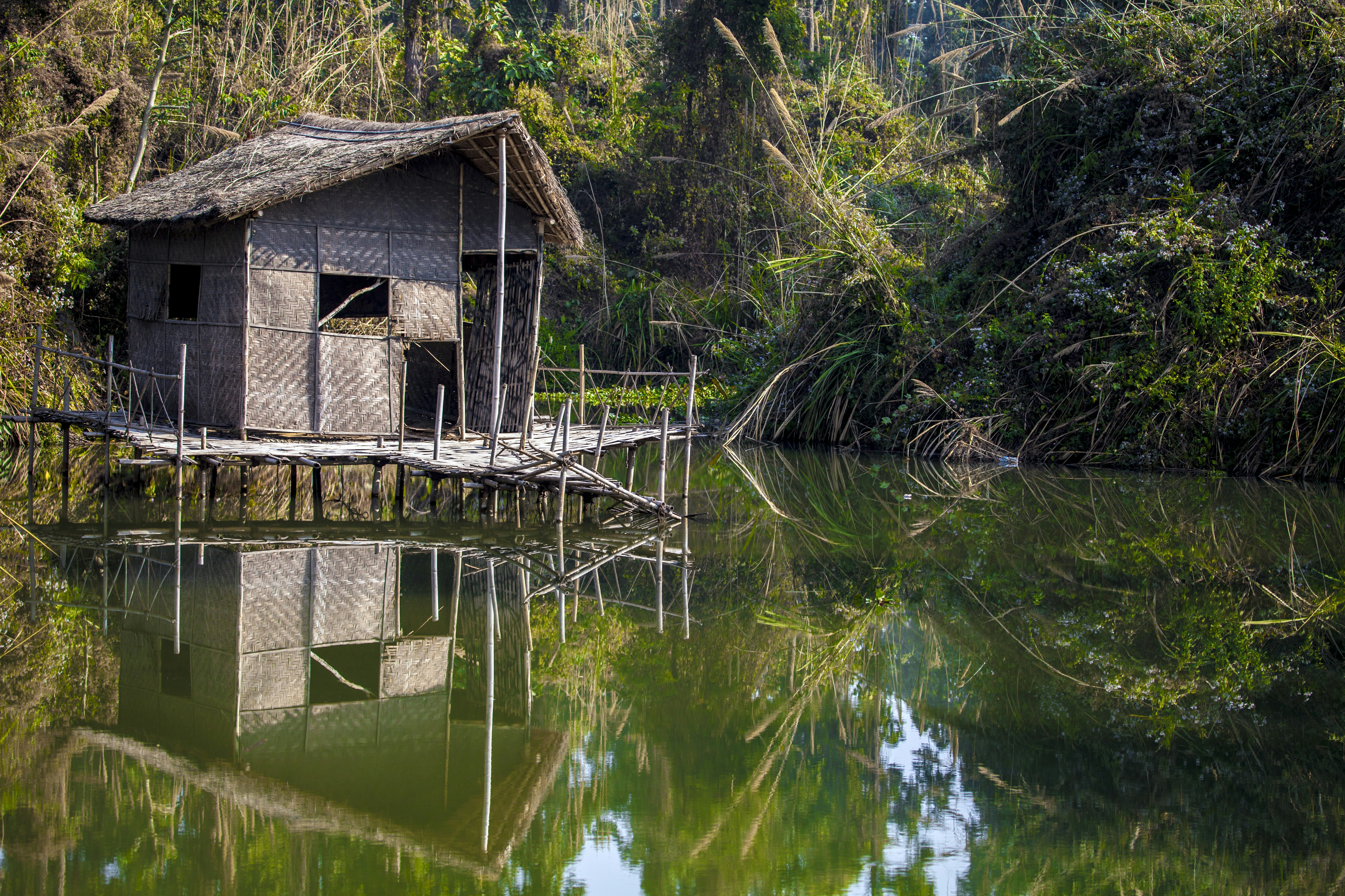 A small hut sitting on top of a body of water photo – Free Biratnagar ...