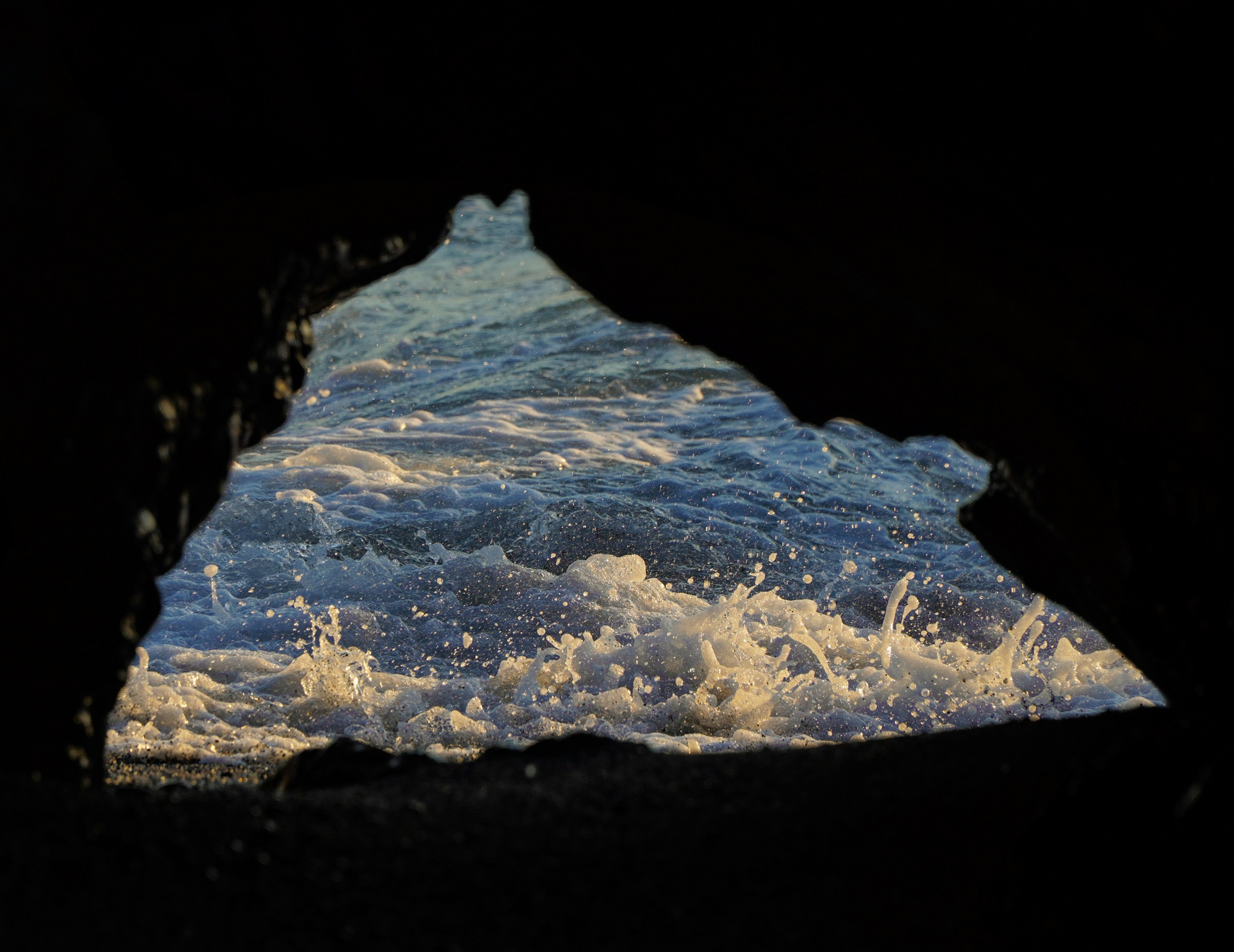 Framed Crest: Sea Foam at the Mouth of a Shadowed Cavern
