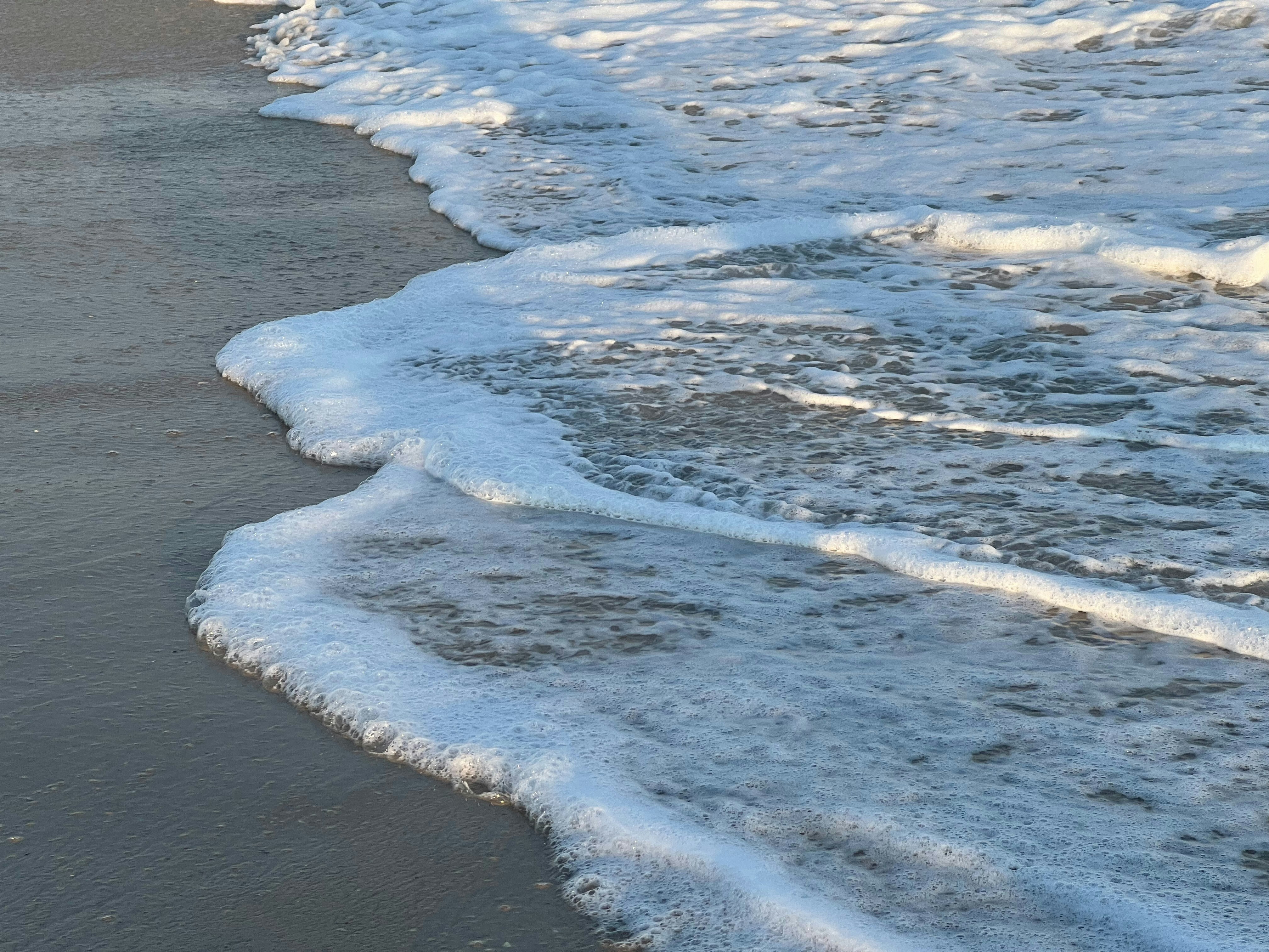 Lacy Foam Fringes Along a Quiet Shoreline