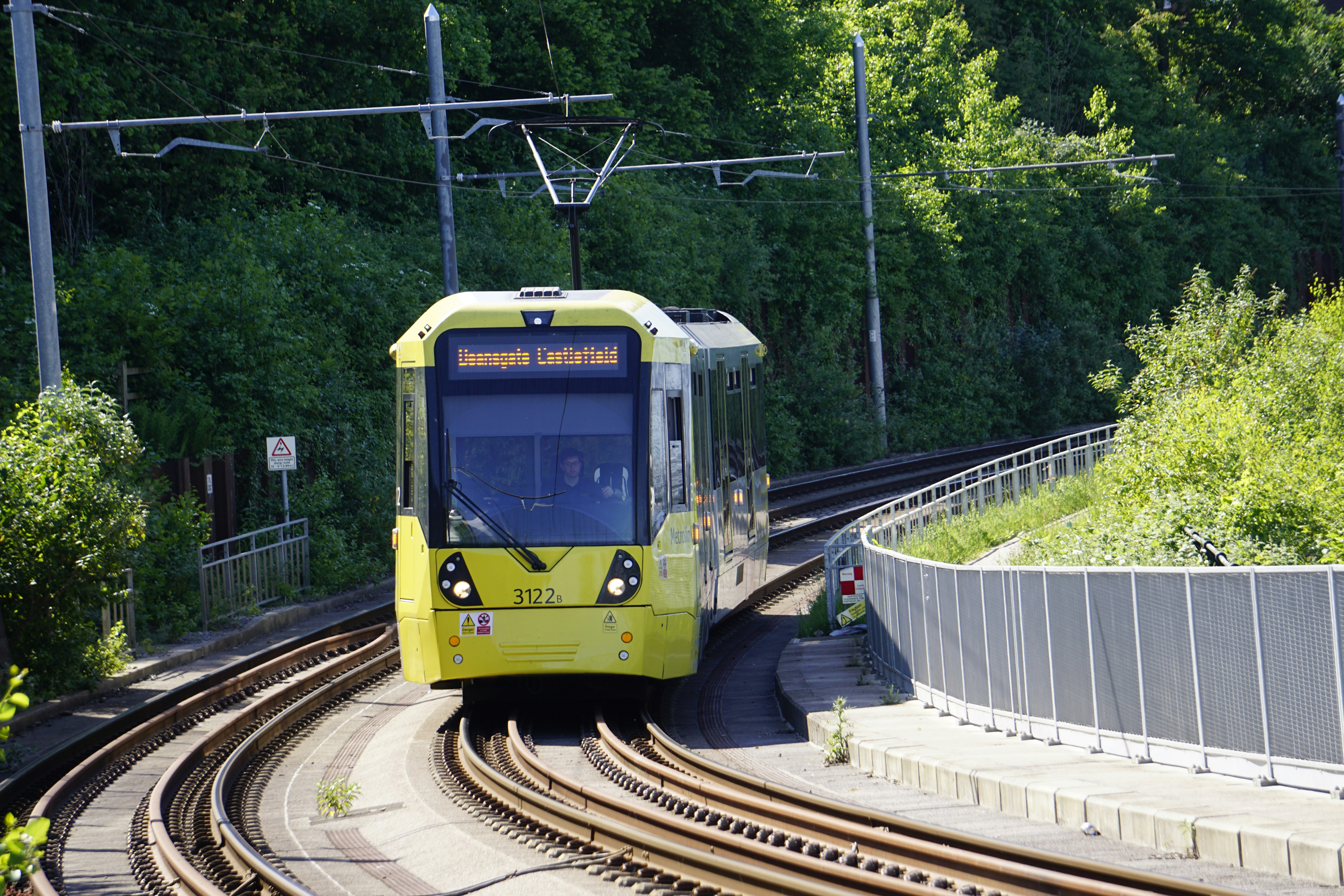 A yellow and blue train traveling down train tracks photo – Free City ...