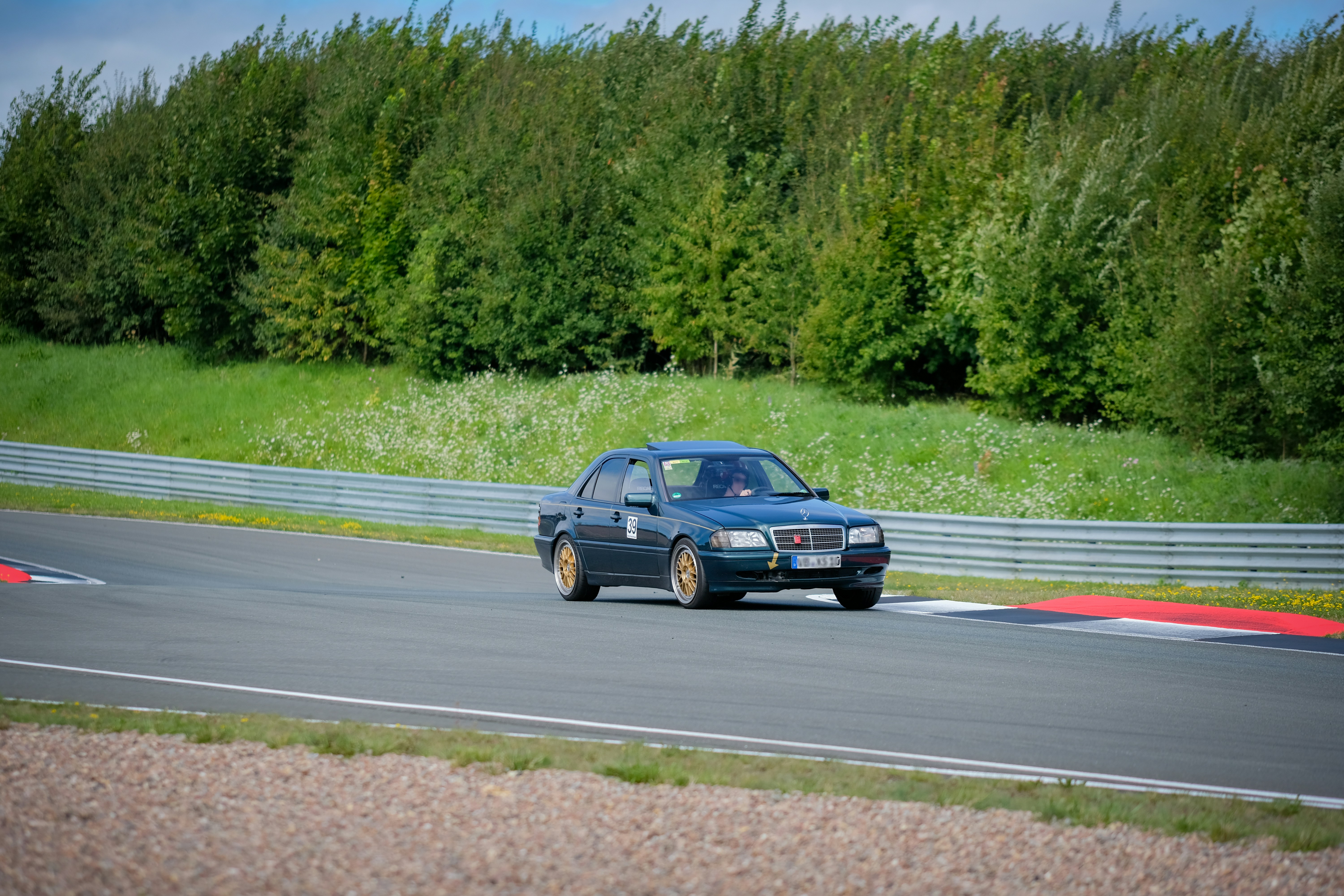 A blue car driving down a race track photo – Free Bilster berg Image on ...
