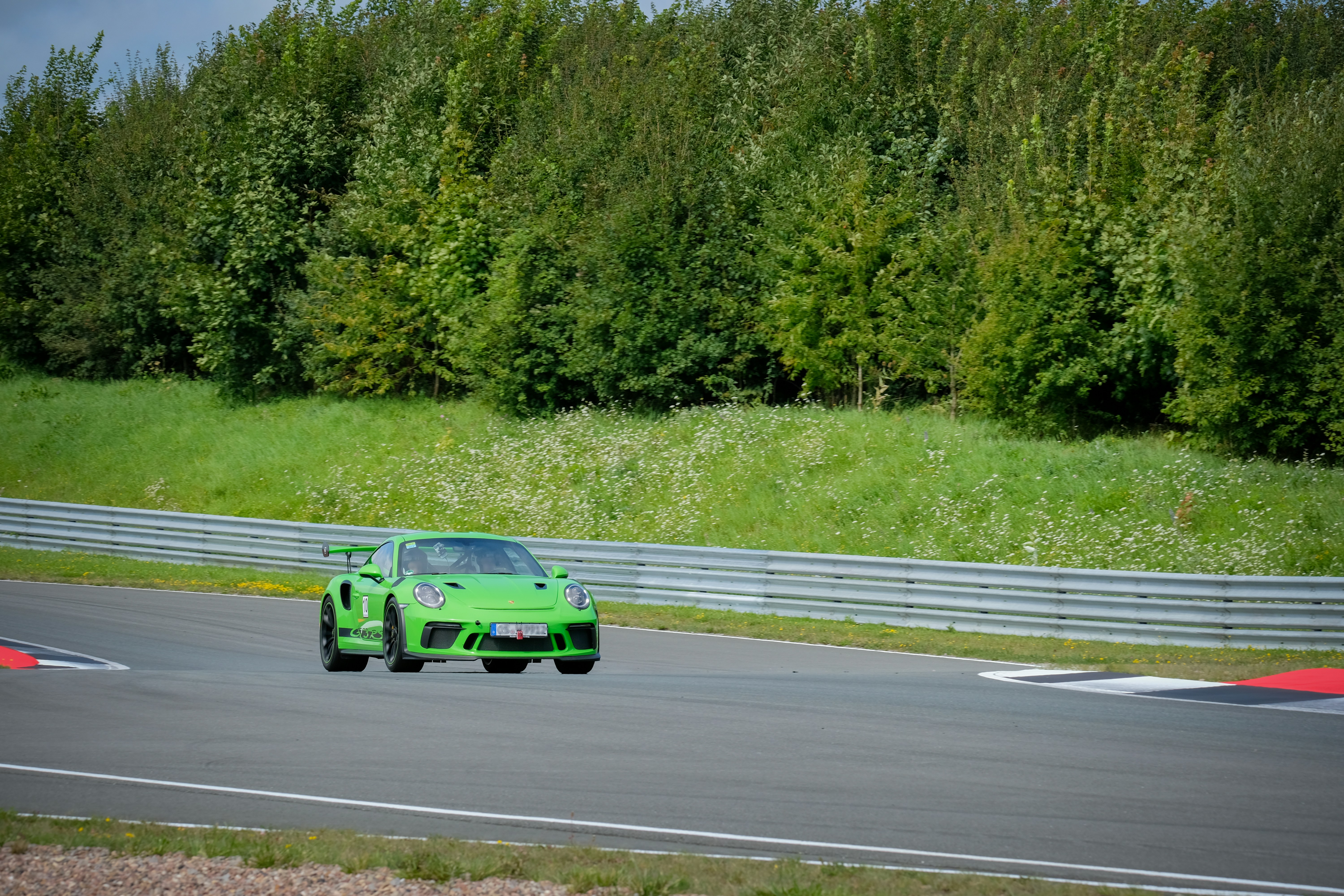 Emerald Blur on the Curve: Lime Porsche Rounds the Red-Trim Chicane