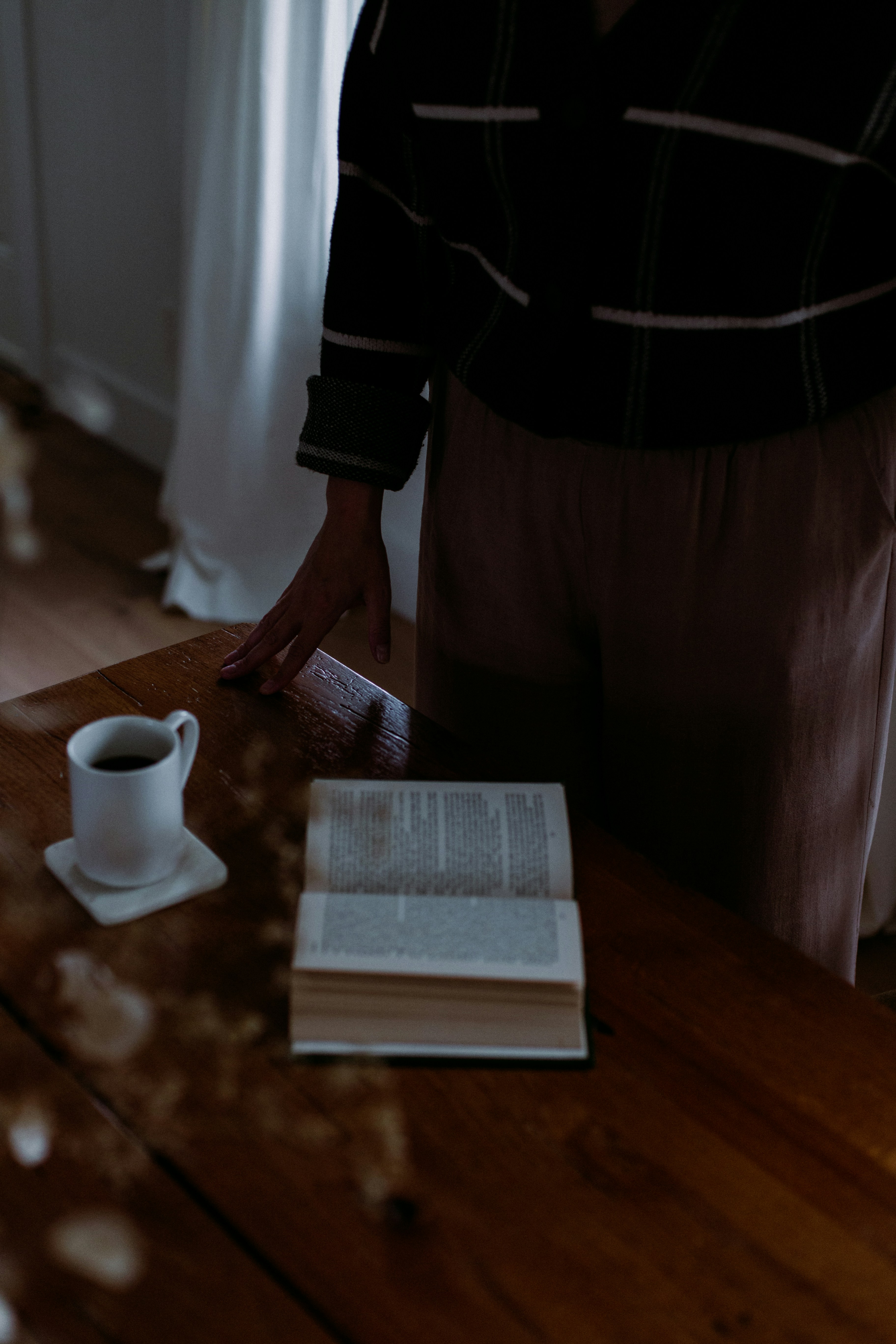 Una persona de pie en una mesa con un libro y una taza de café foto ...