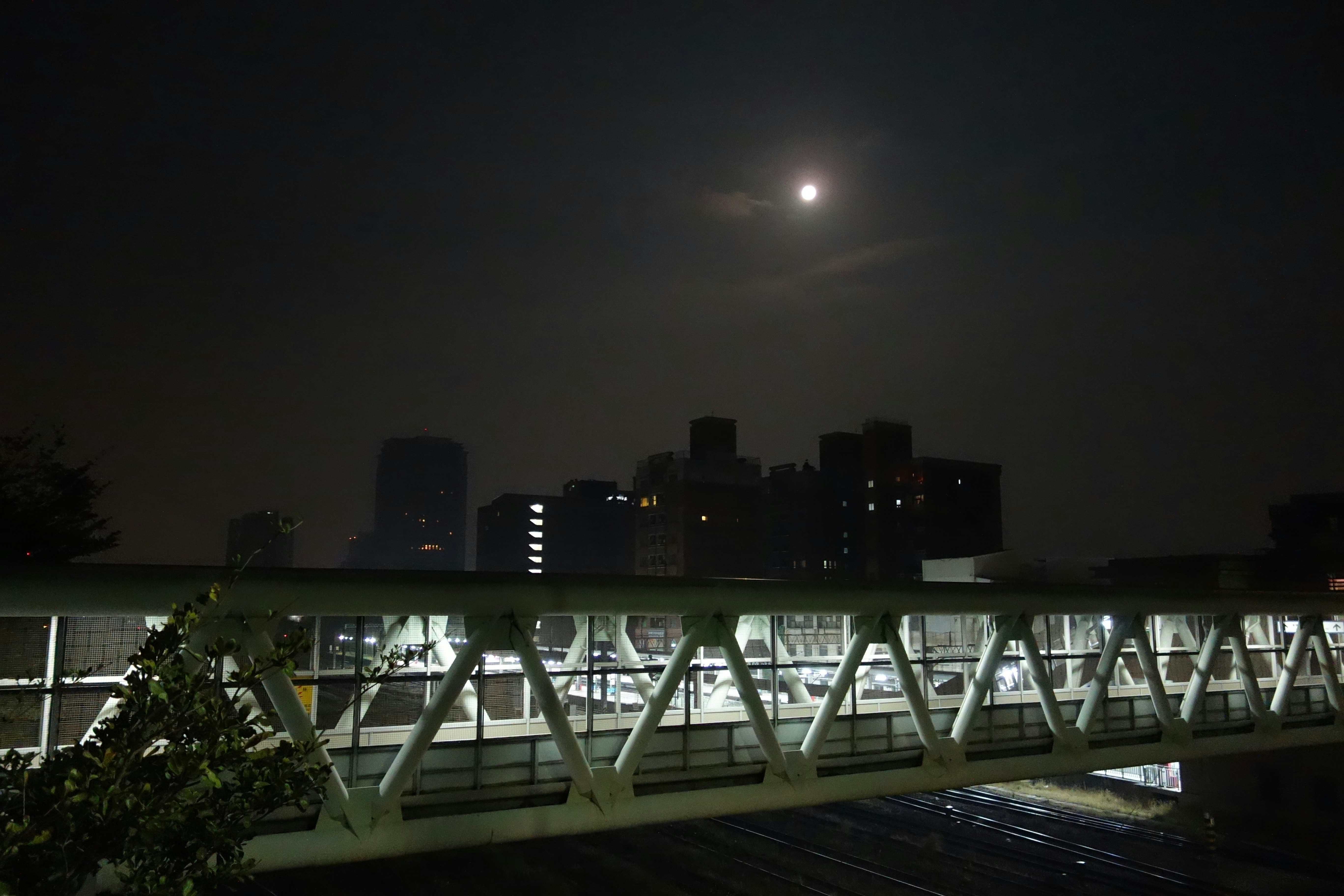Moonlit Truss and Quiet Skyline: Nighttime Bridge Over a Sleeping City
