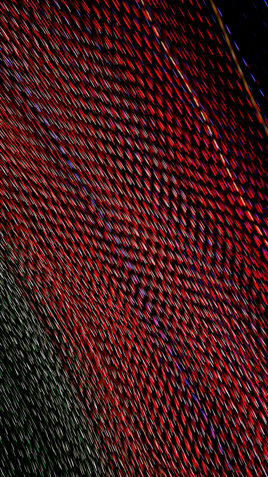 Abstract diagonal streaks of red, white, and blue light sweep across a dark background.
