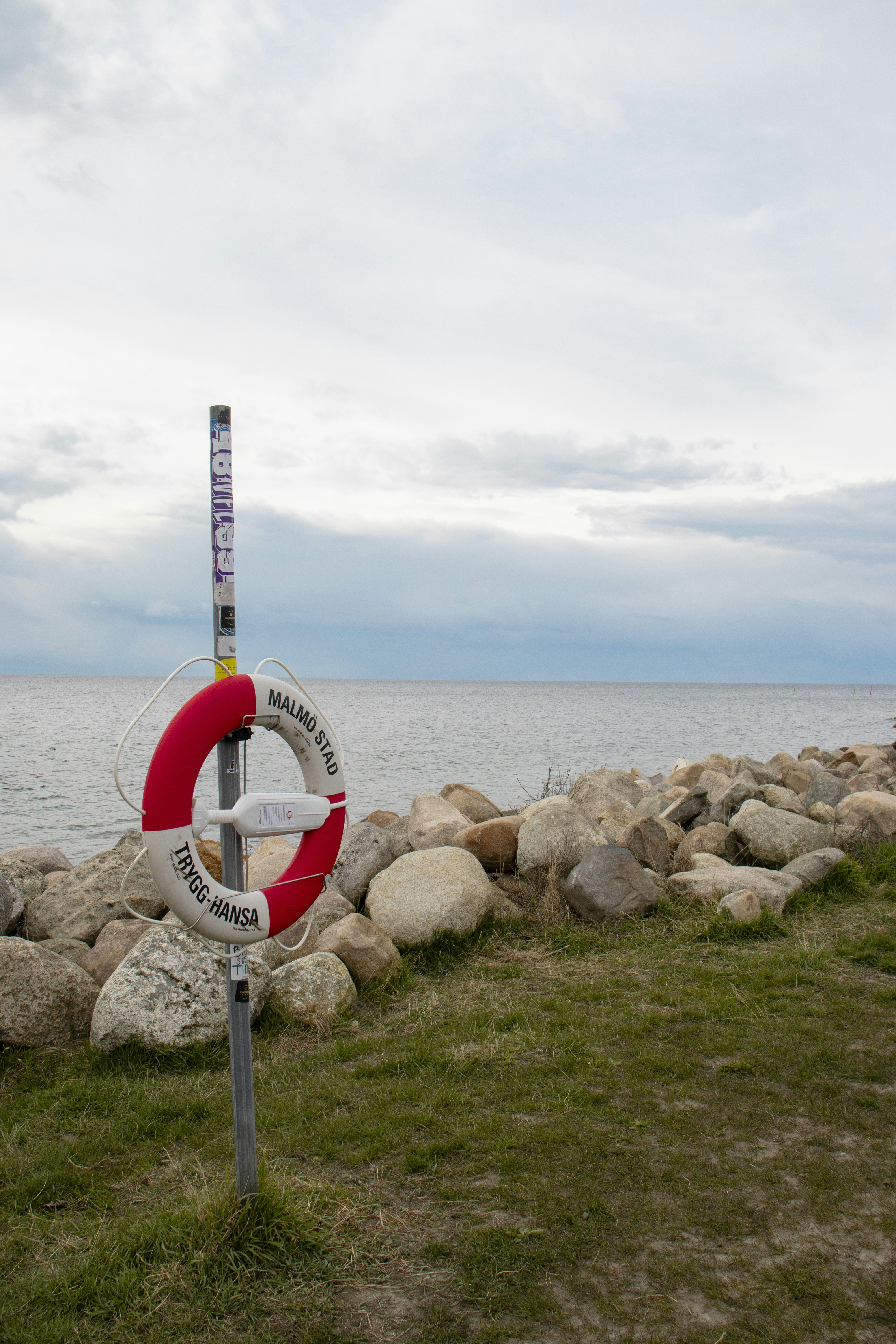 Red Lifebuoy Sentinel by a Rocky Baltic Shore