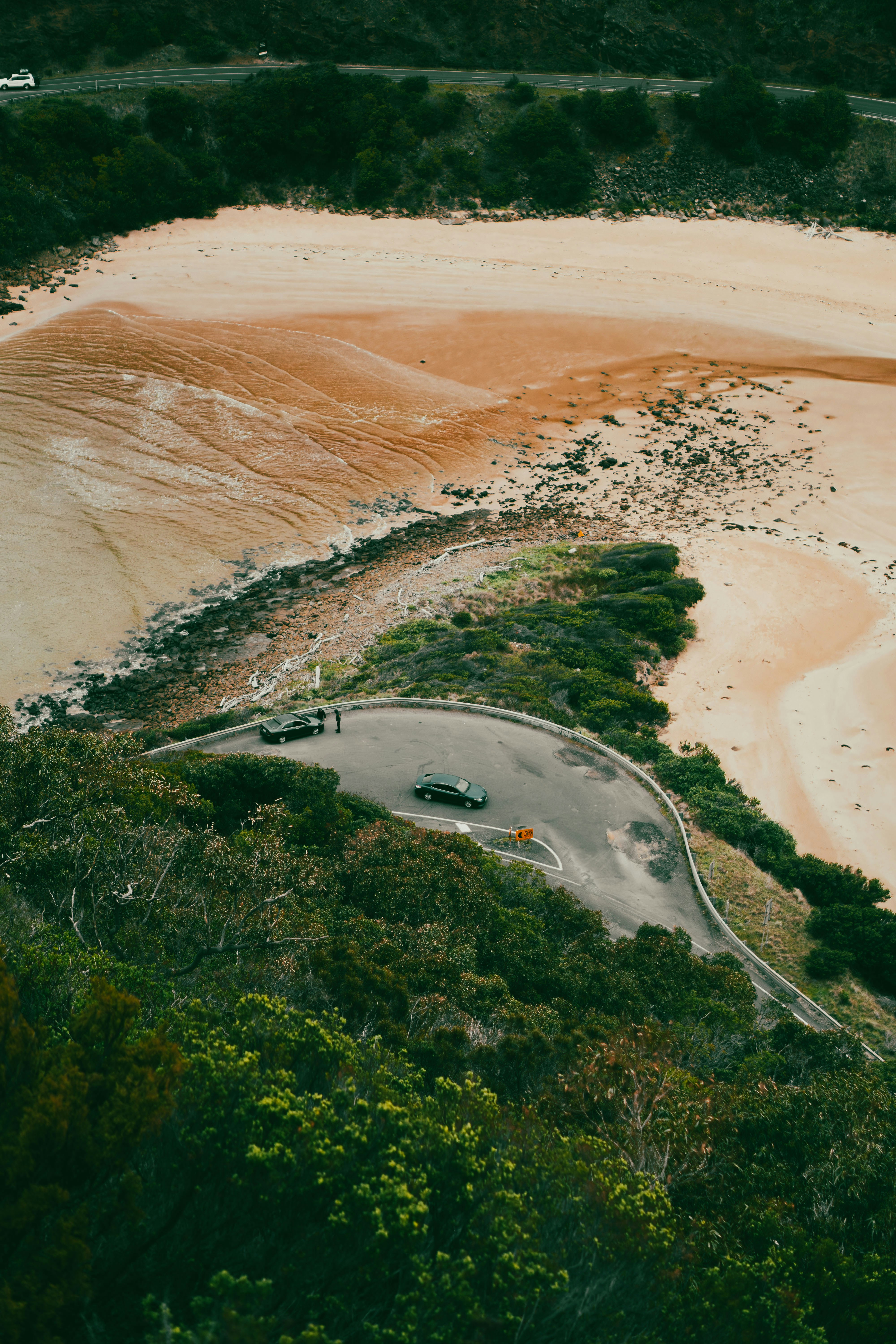 Clifftop Switchback Overlook: Cars Winding Above the Shore