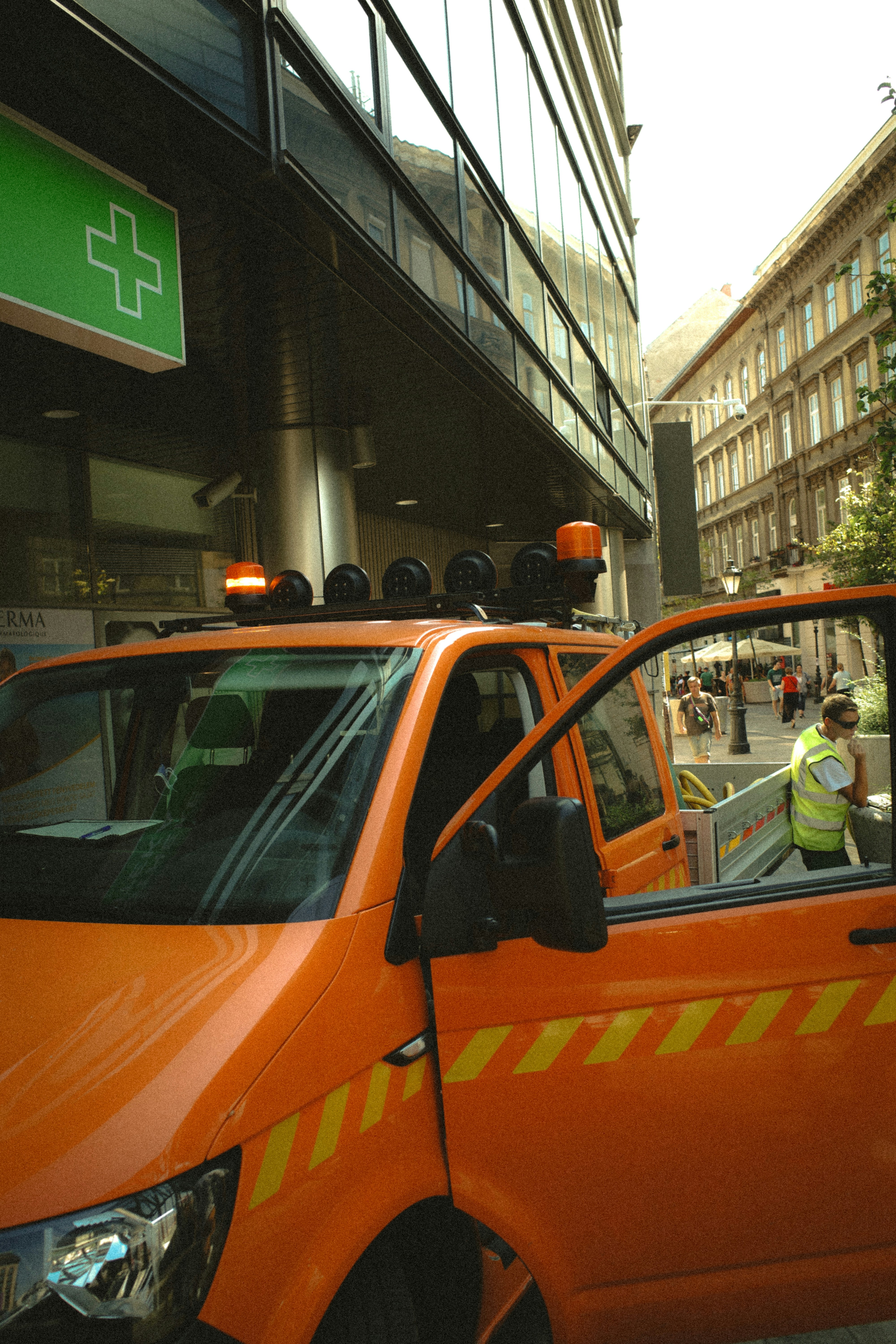 Orange Utility Van at a Sunlit City Corner: Street-Work and Urban Flow