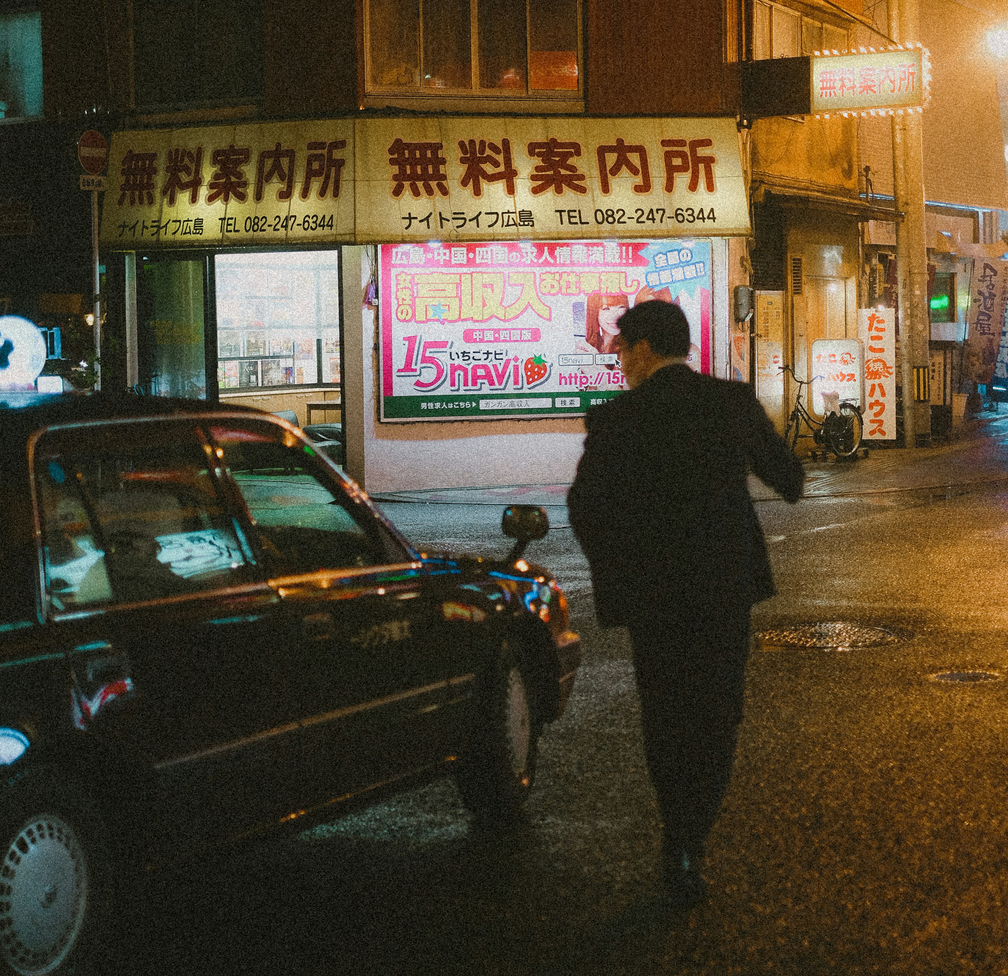 Midnight Neon Walk: A Suit-Clad Silhouette on a Rain-Slick Japanese Street