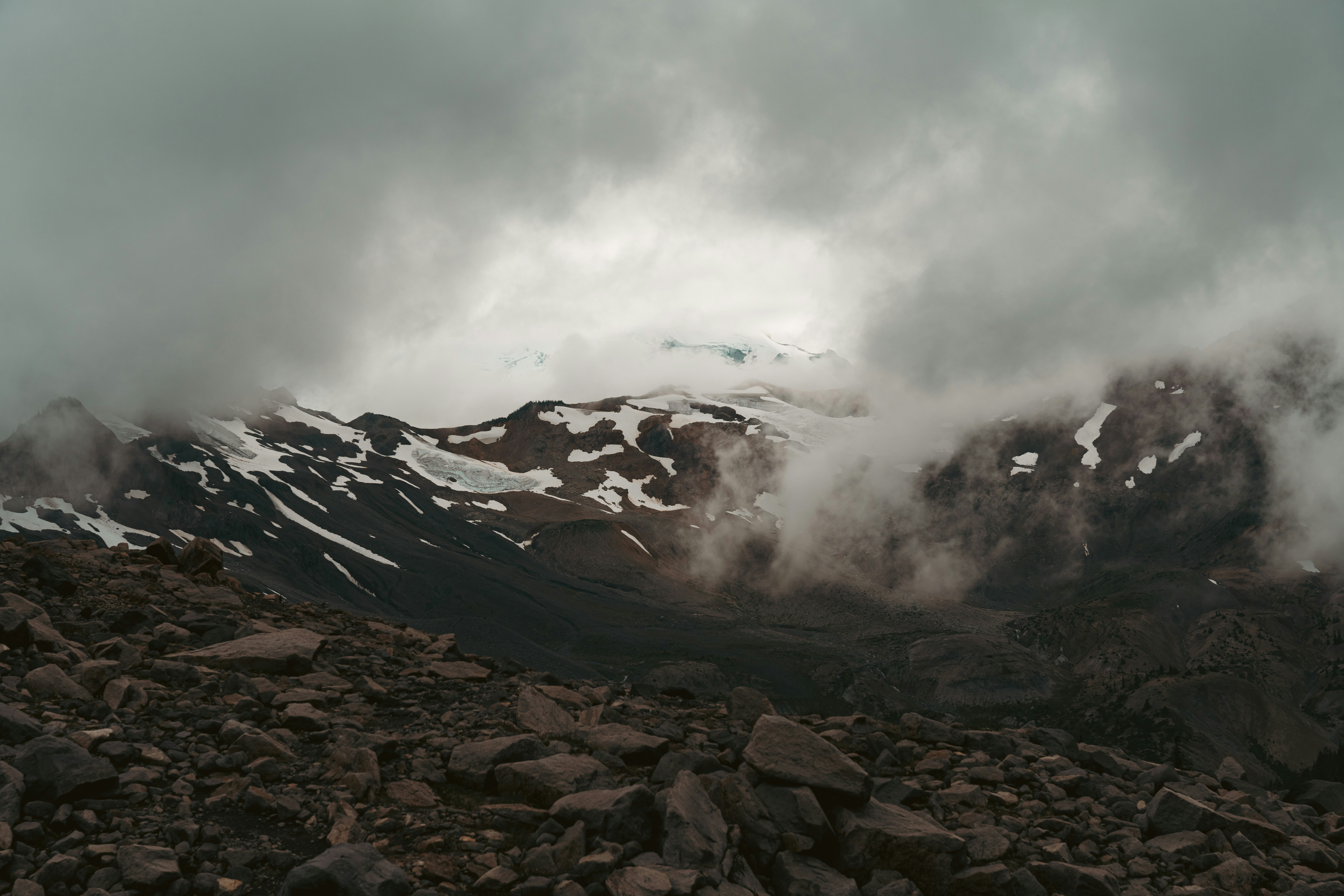 A mountain covered in snow and clouds on a cloudy day photo – Free ...