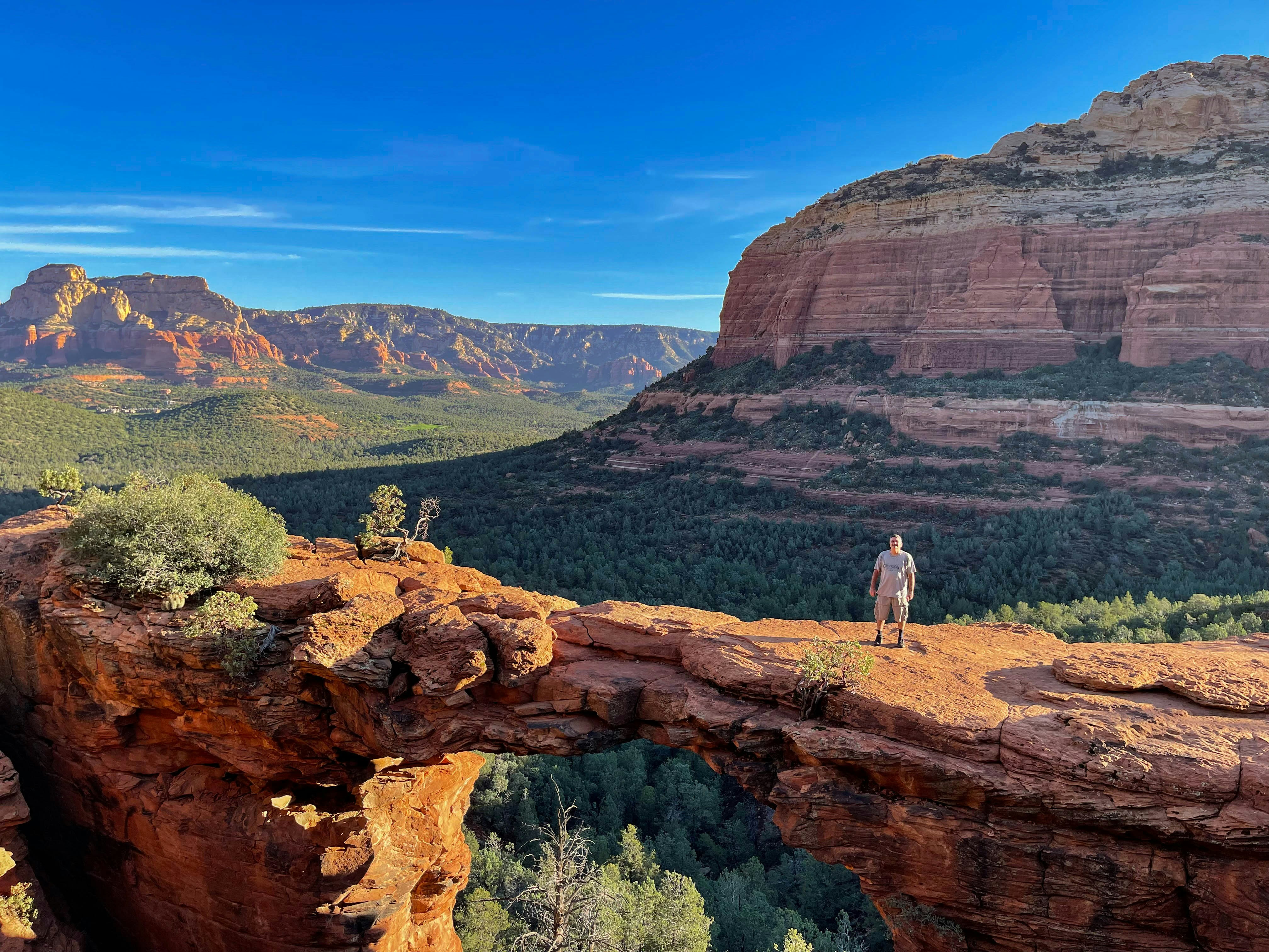 Edge of the Mesa: Lone Figure Beneath the Red Rock Monolith
