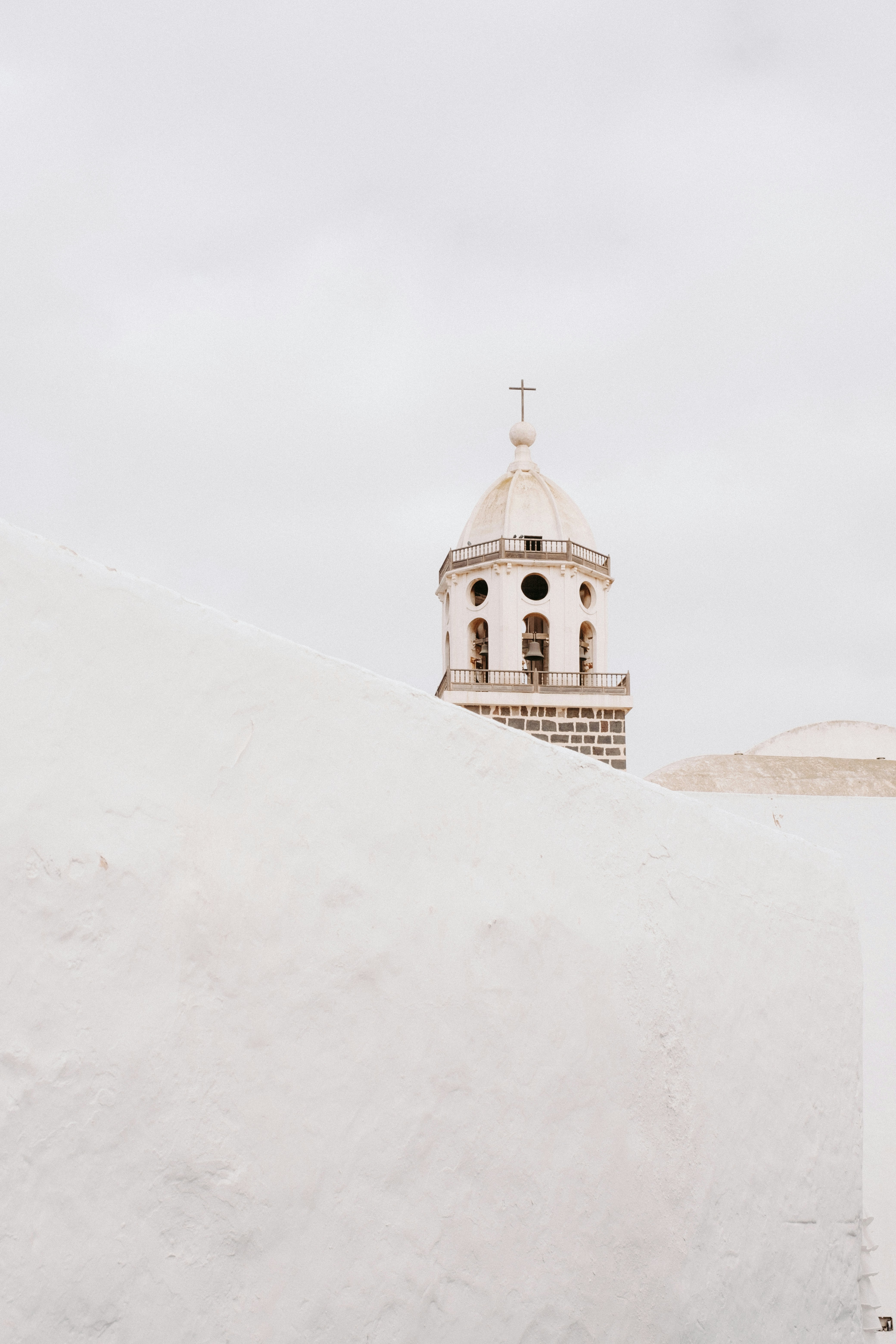 Whitewashed Dusk: Church Bell Tower Peeking Over a Quiet Ridge