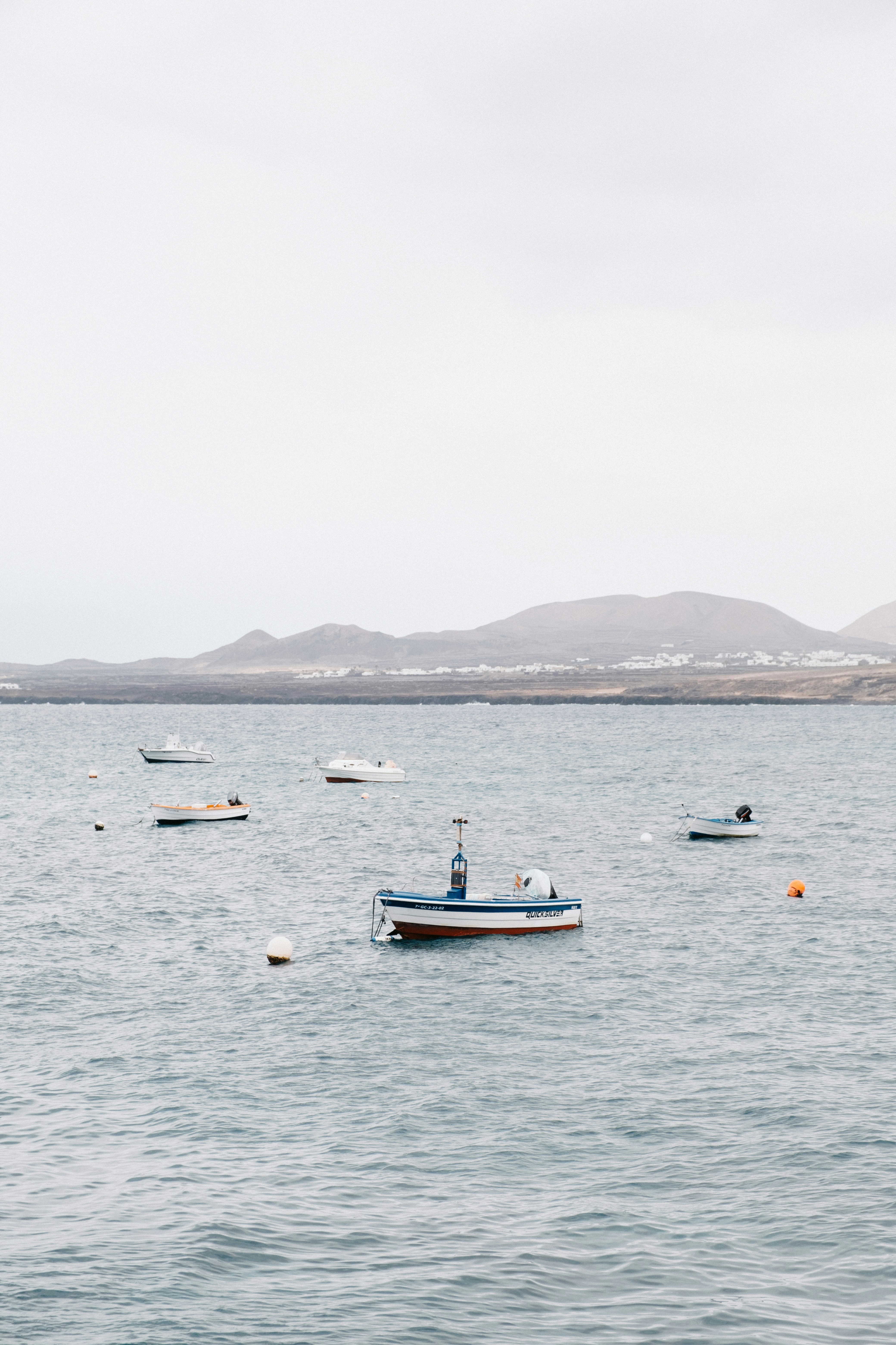 Un gruppo di barche che galleggiano sopra un grande specchio d'acqua ...