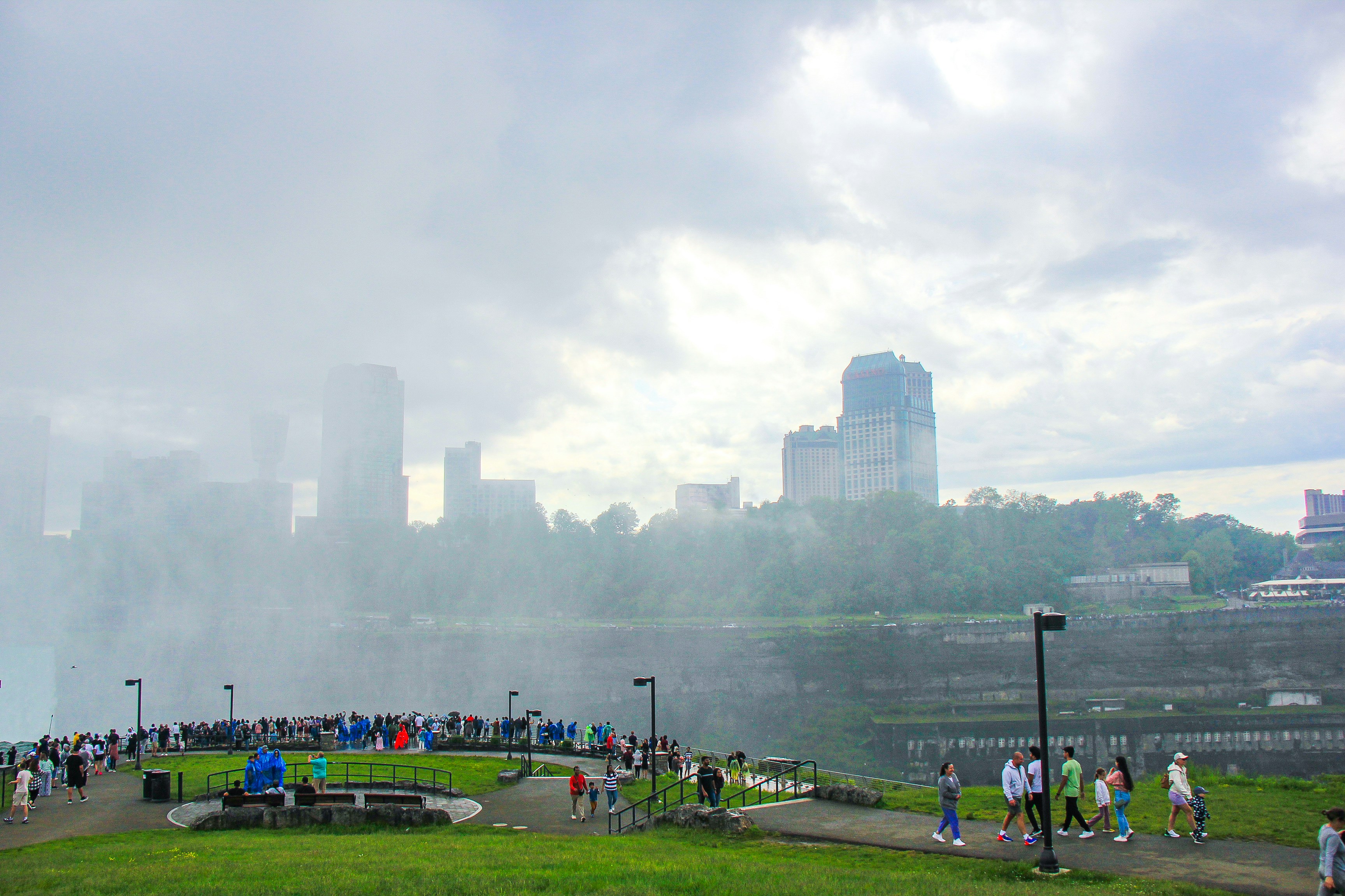 Fog Over the Riverside: Crowds at a Circular Fountain Beneath a Veiled Skyline