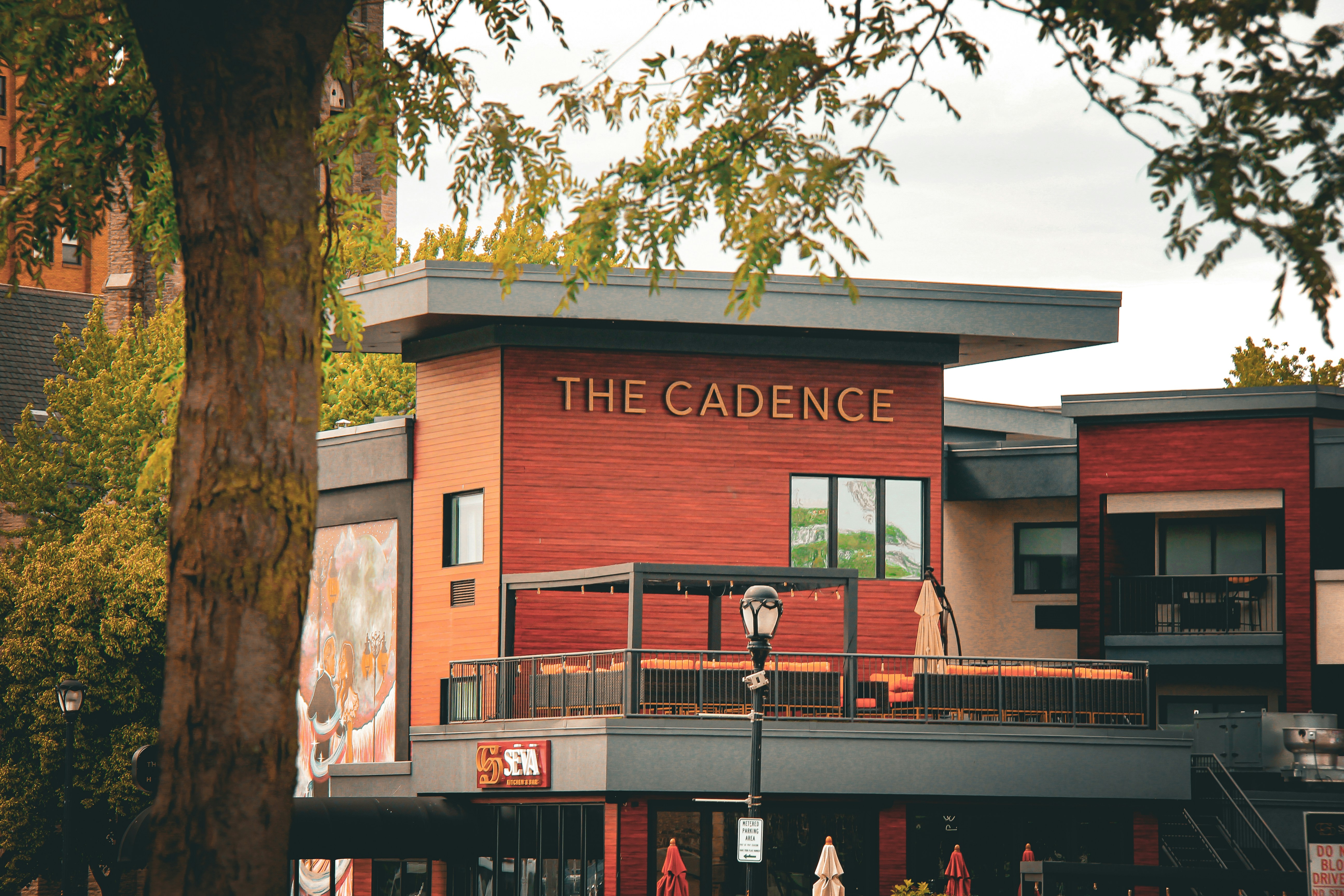 The Cadence Sign Above a Brick Facade with Balcony Terrace