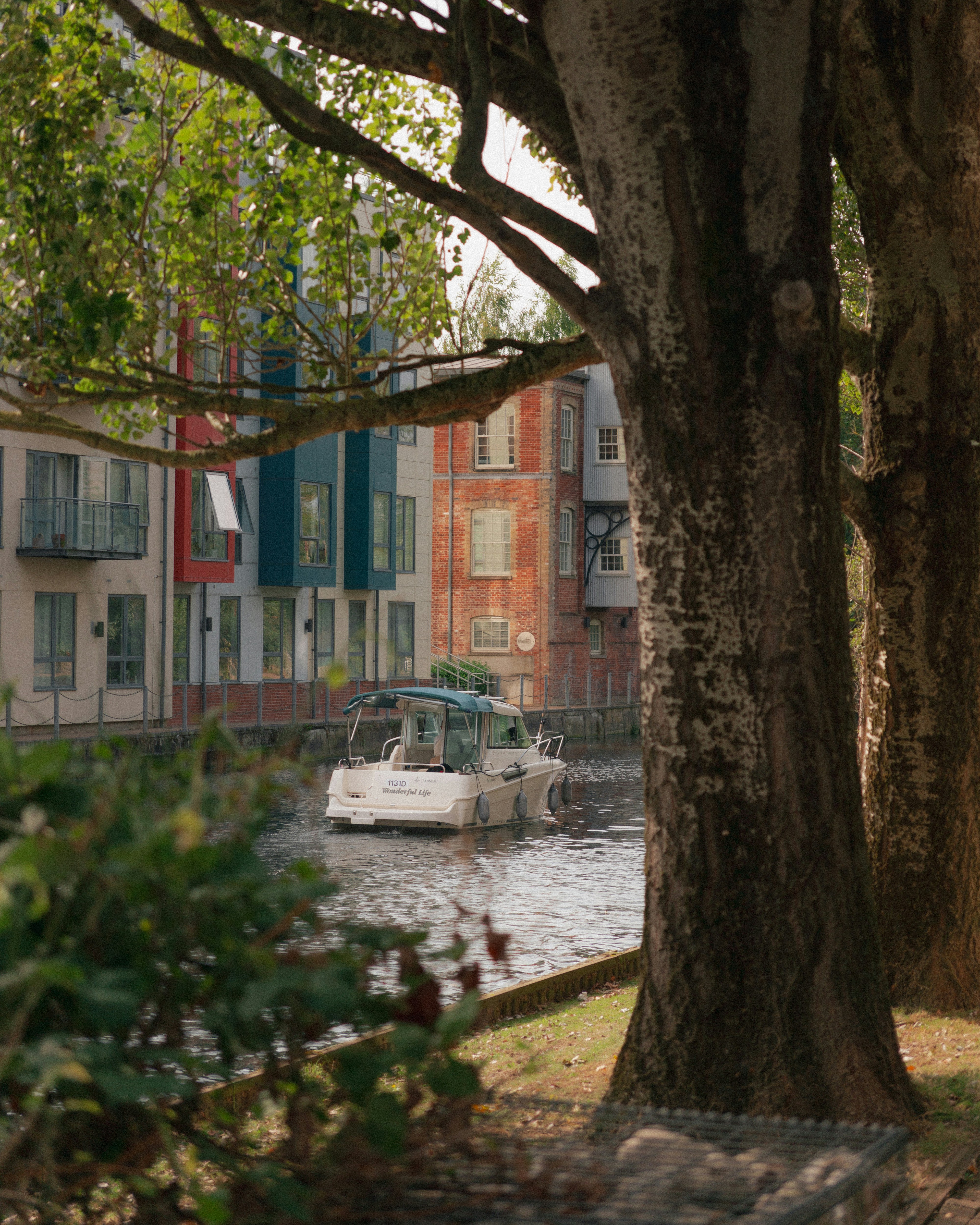 A boat floating down a river next to tall buildings photo – Free ...