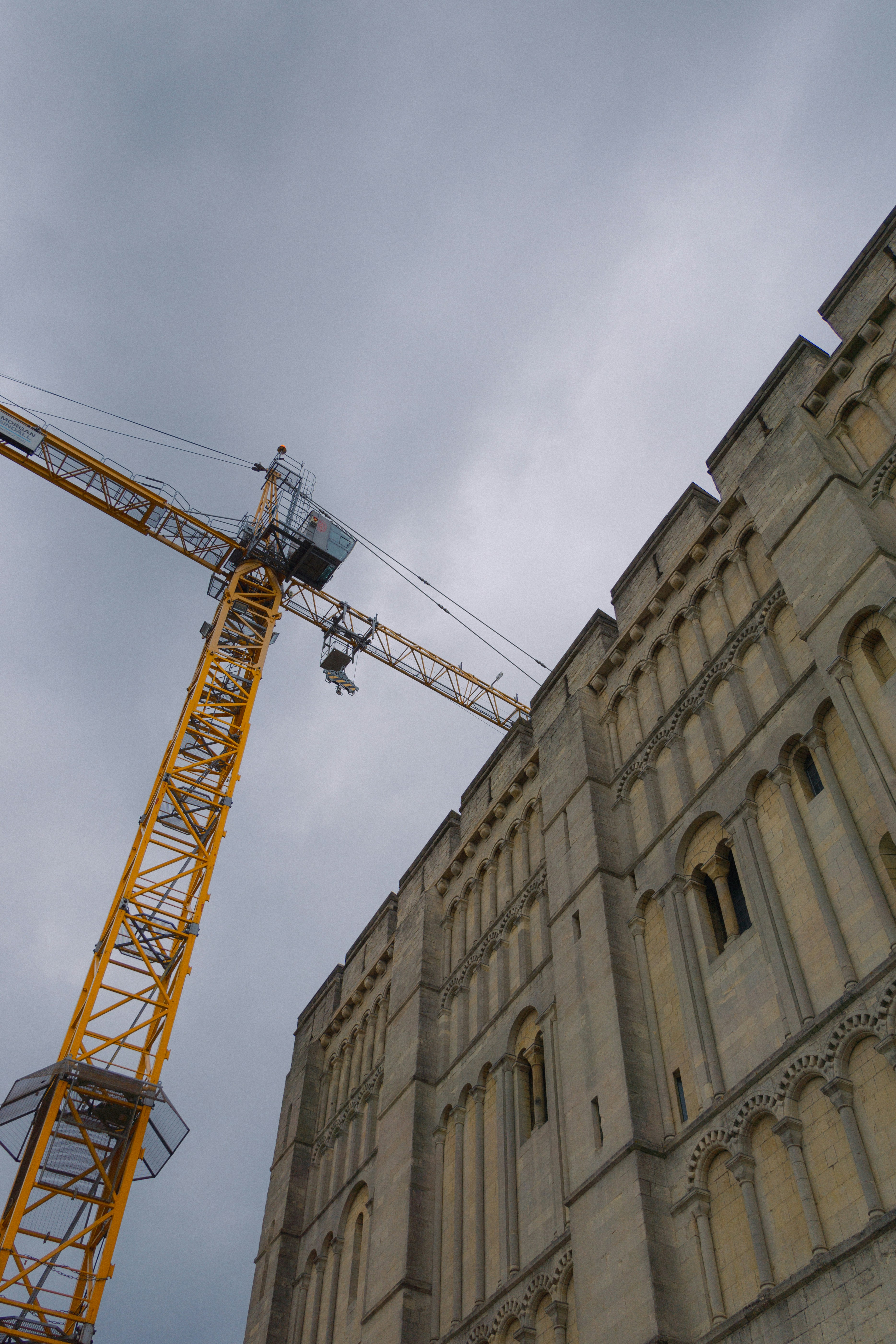 Tower Crane Over Historic Facade Under Gray Sky