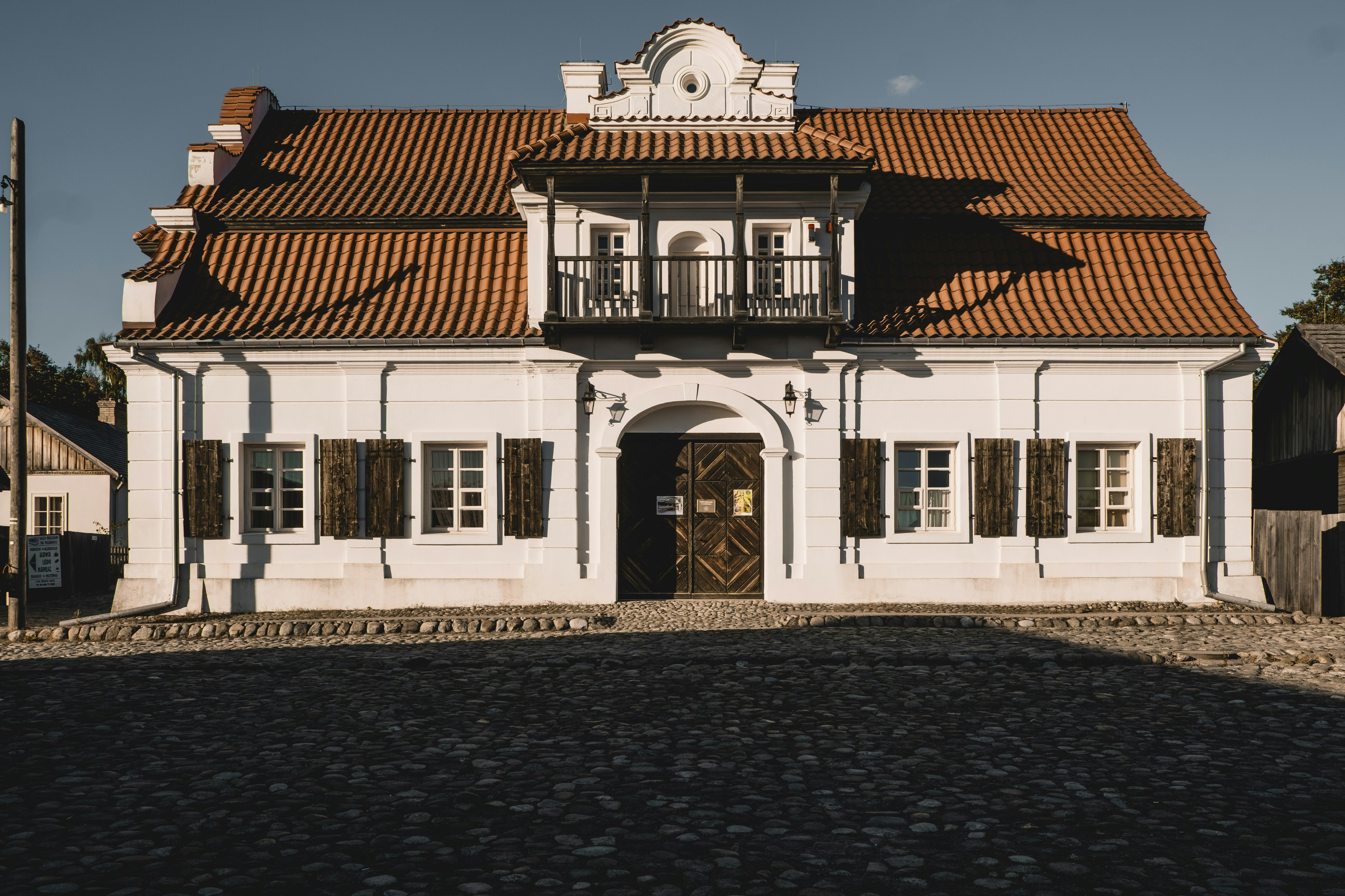 Center Archway Serenade: A Timeless White Facade with a Red Tile Roof