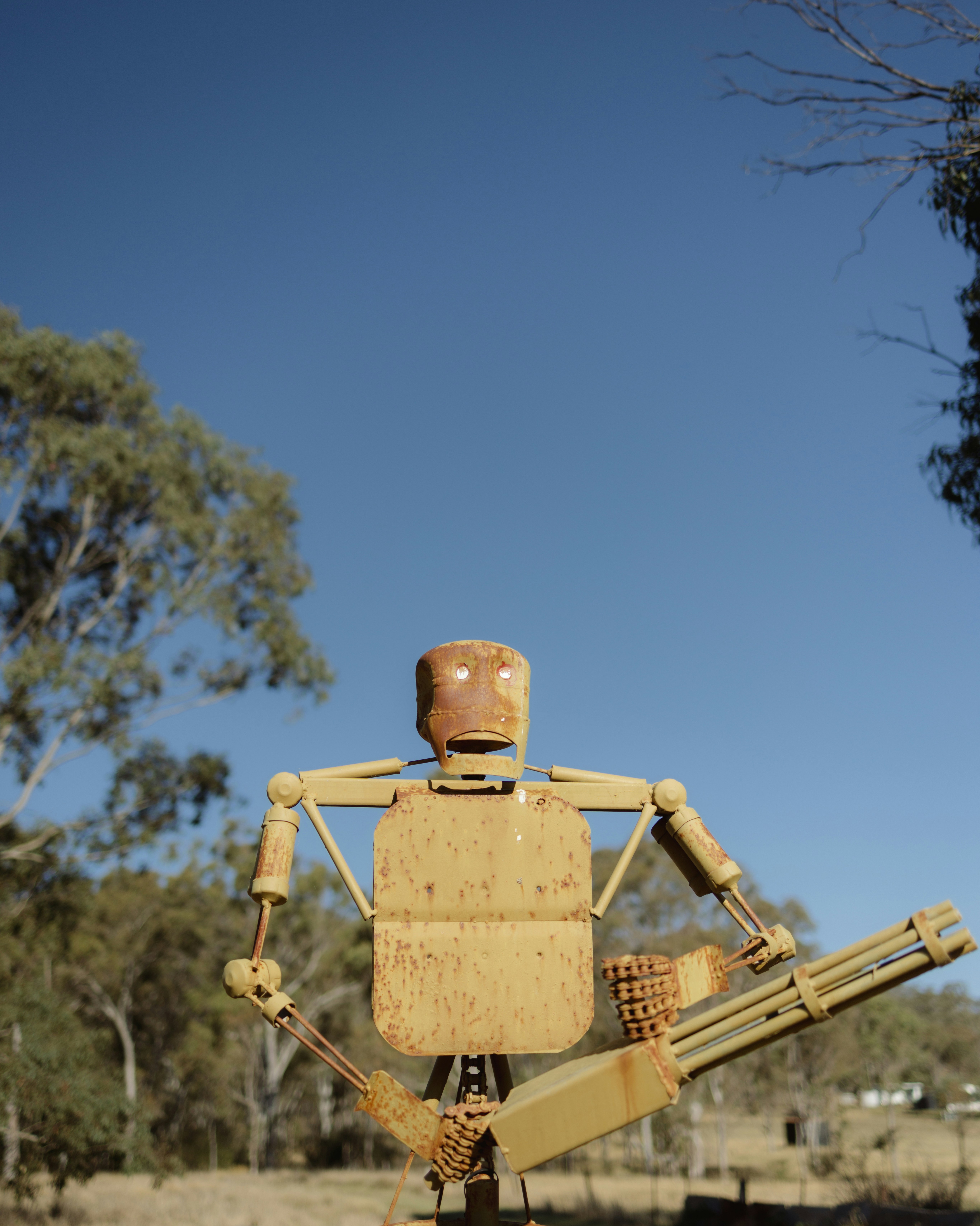 Rusty Robot Sentinel Under a Wide Blue Sky