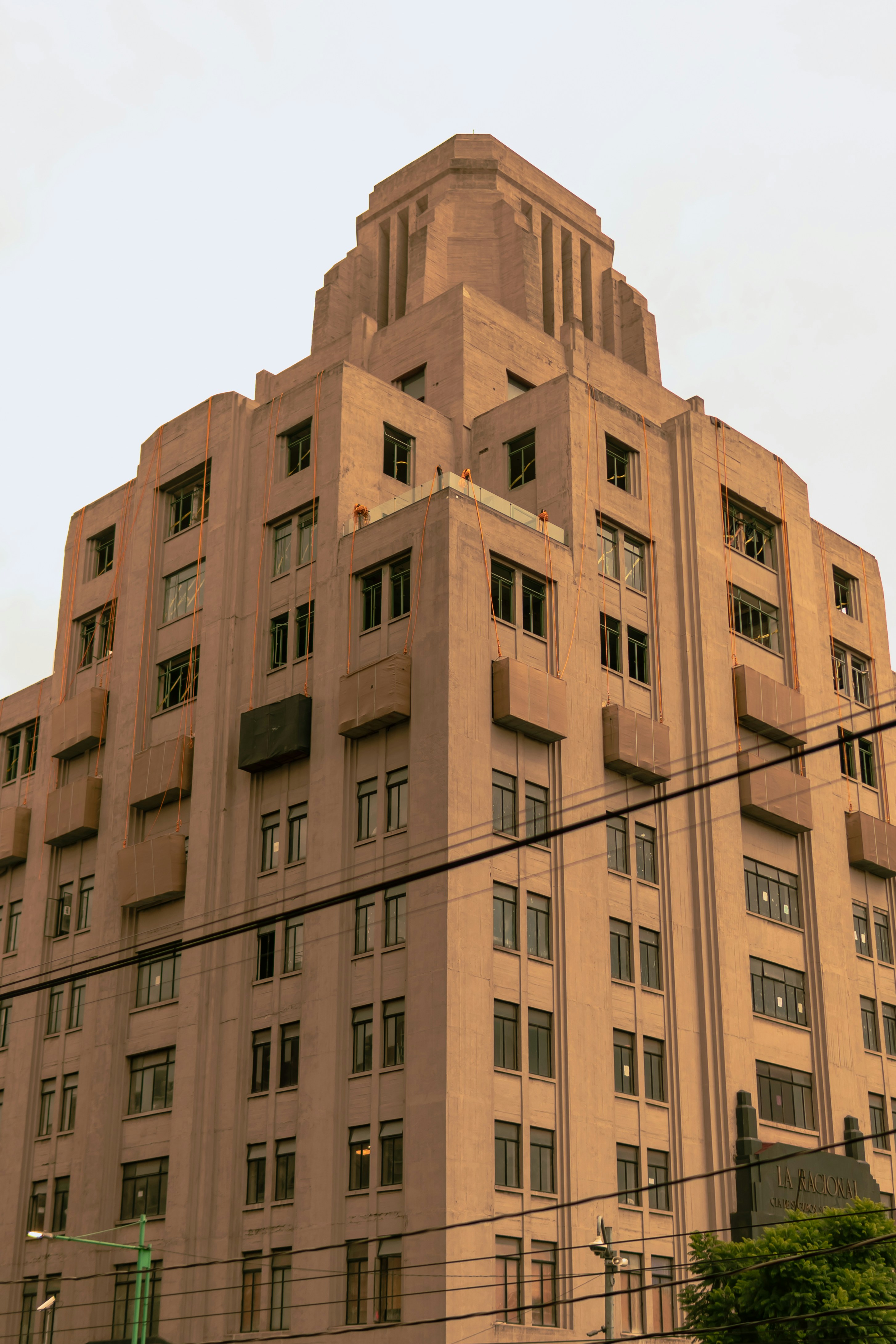 Sunlit Steps: Beige Art Deco Tower Rising Above a Windowed Grid