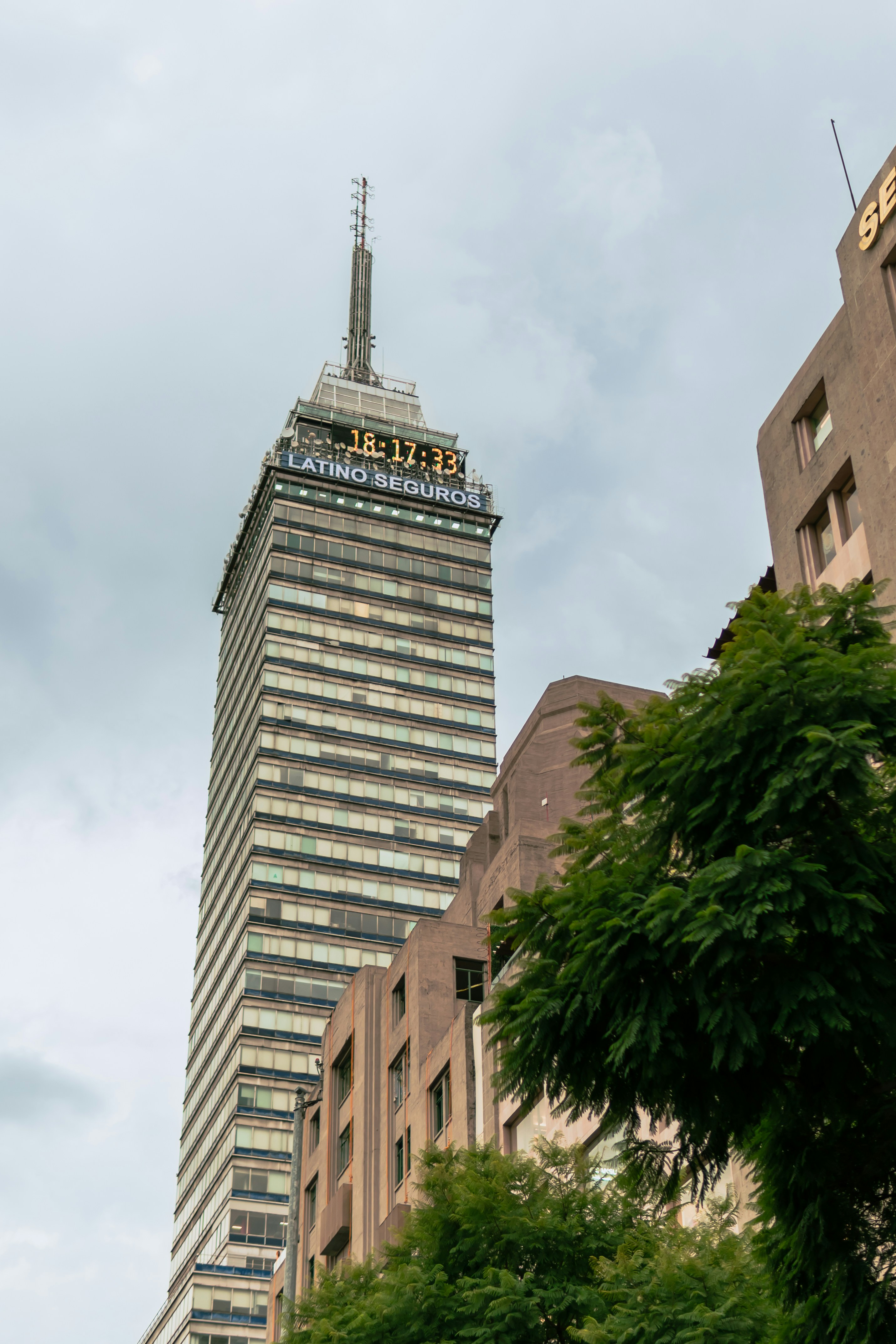 A tall building with a sky scraper on top of it photo – Free City Image ...