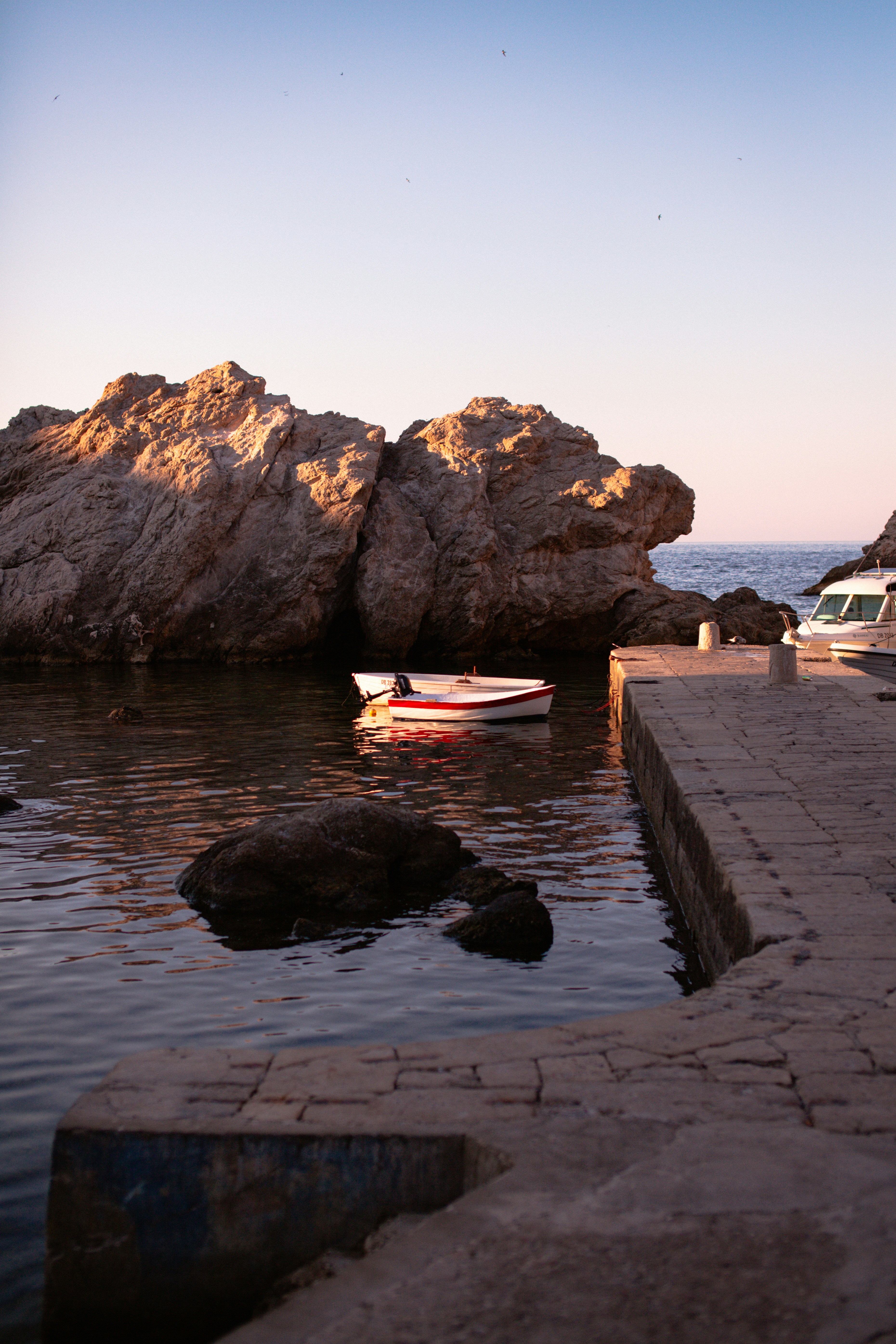 Harbor at Golden Hour: Boats, Rockscape, and Quiet Pier