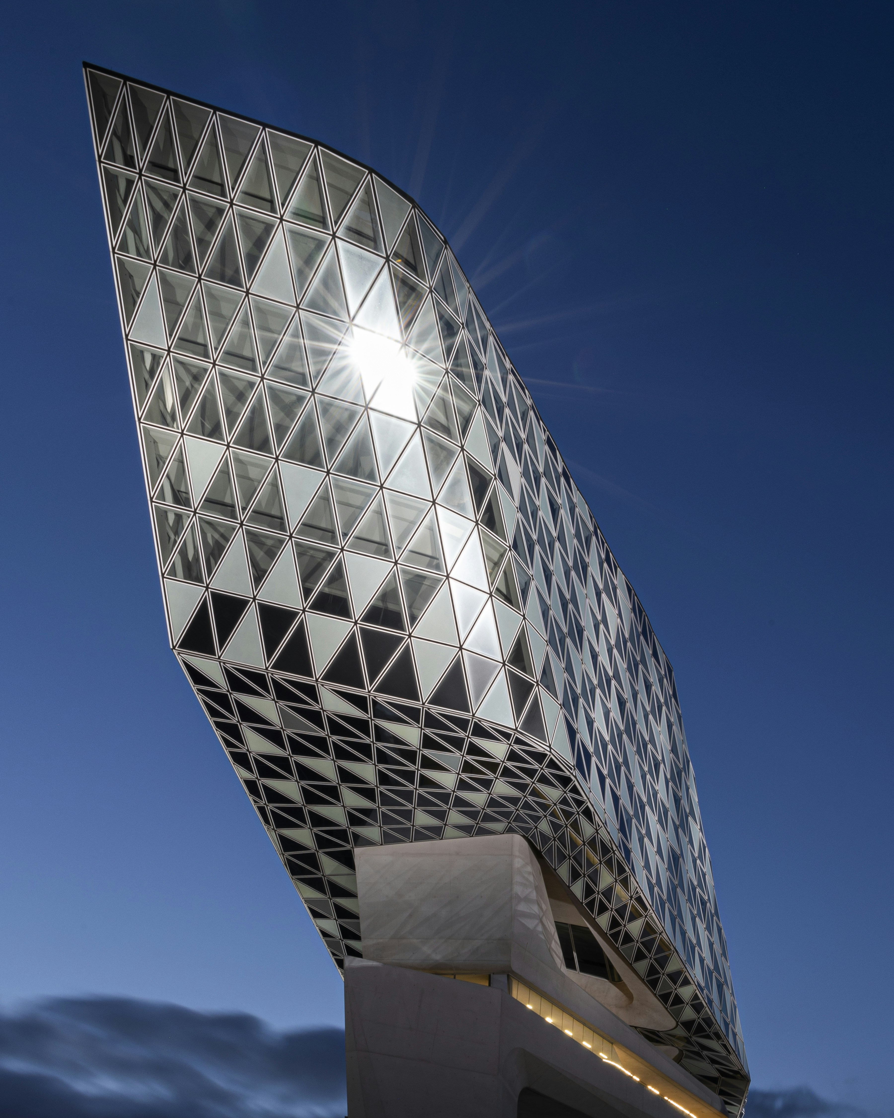 A tall building with a triangular design on it's side photo – Free ...