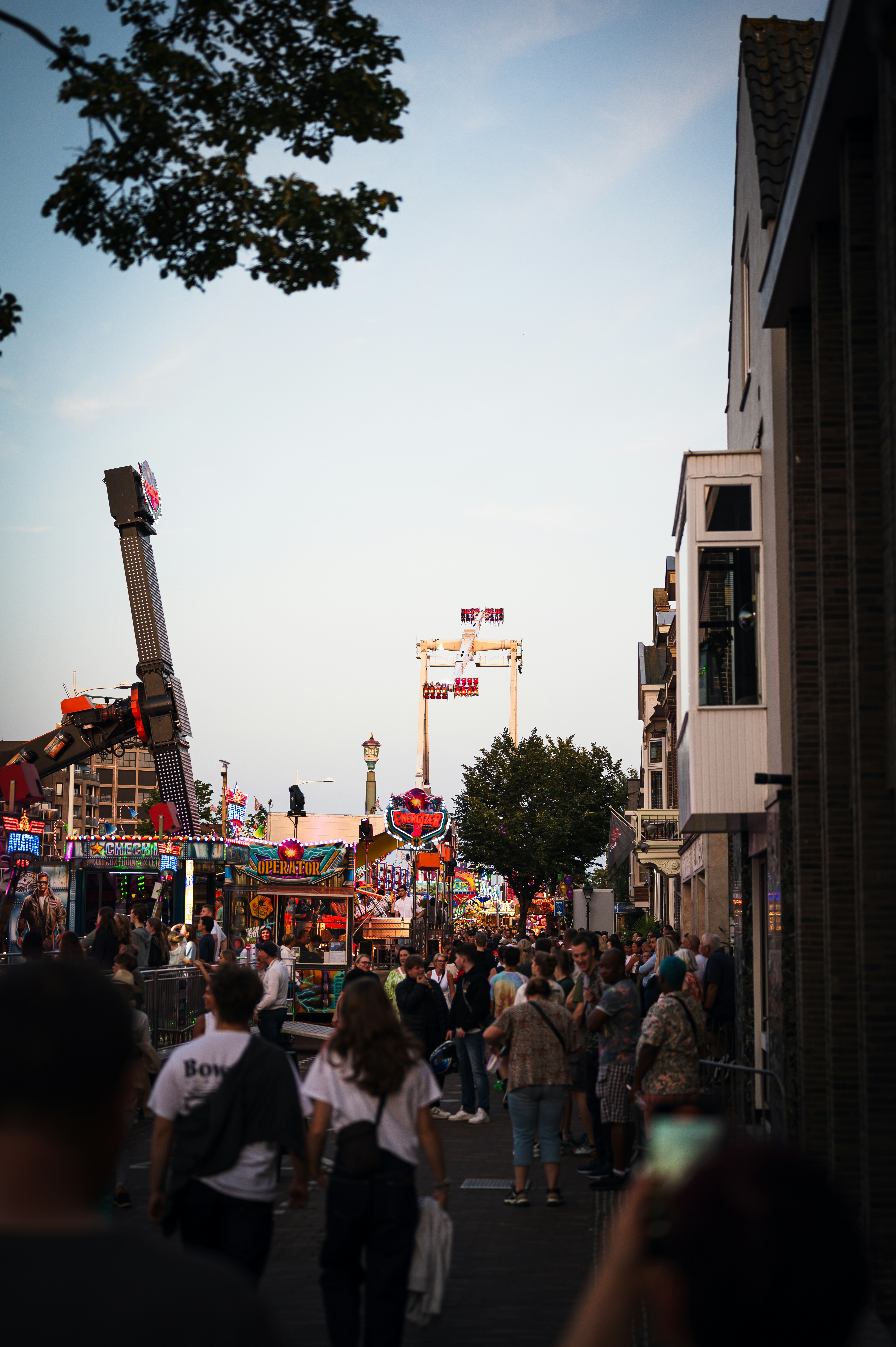 Sunlit Street Fair Corridor: Faces in the Foreground, Rides in the Distance