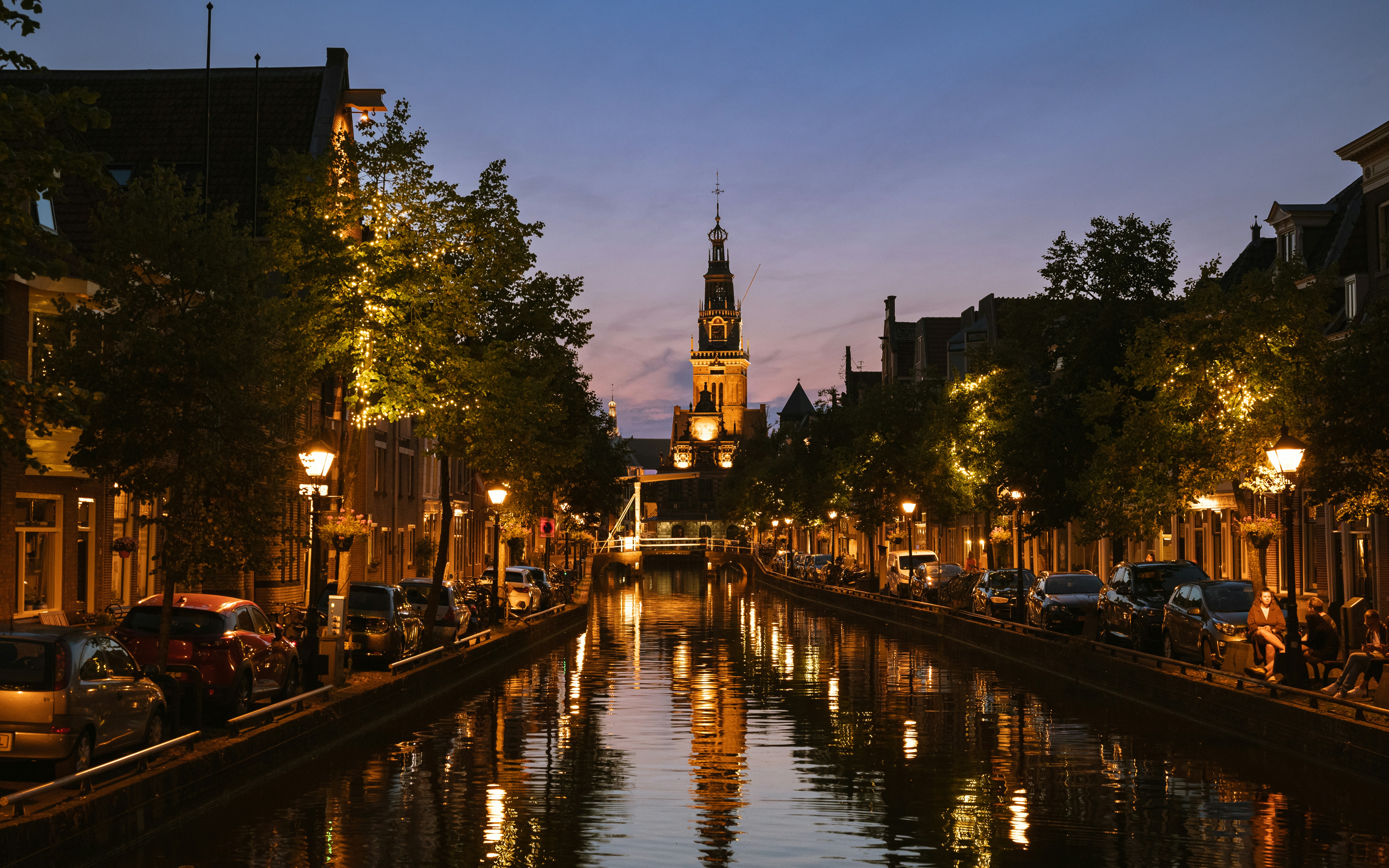 A canal with a clock tower in the background photo – Free City Image on ...