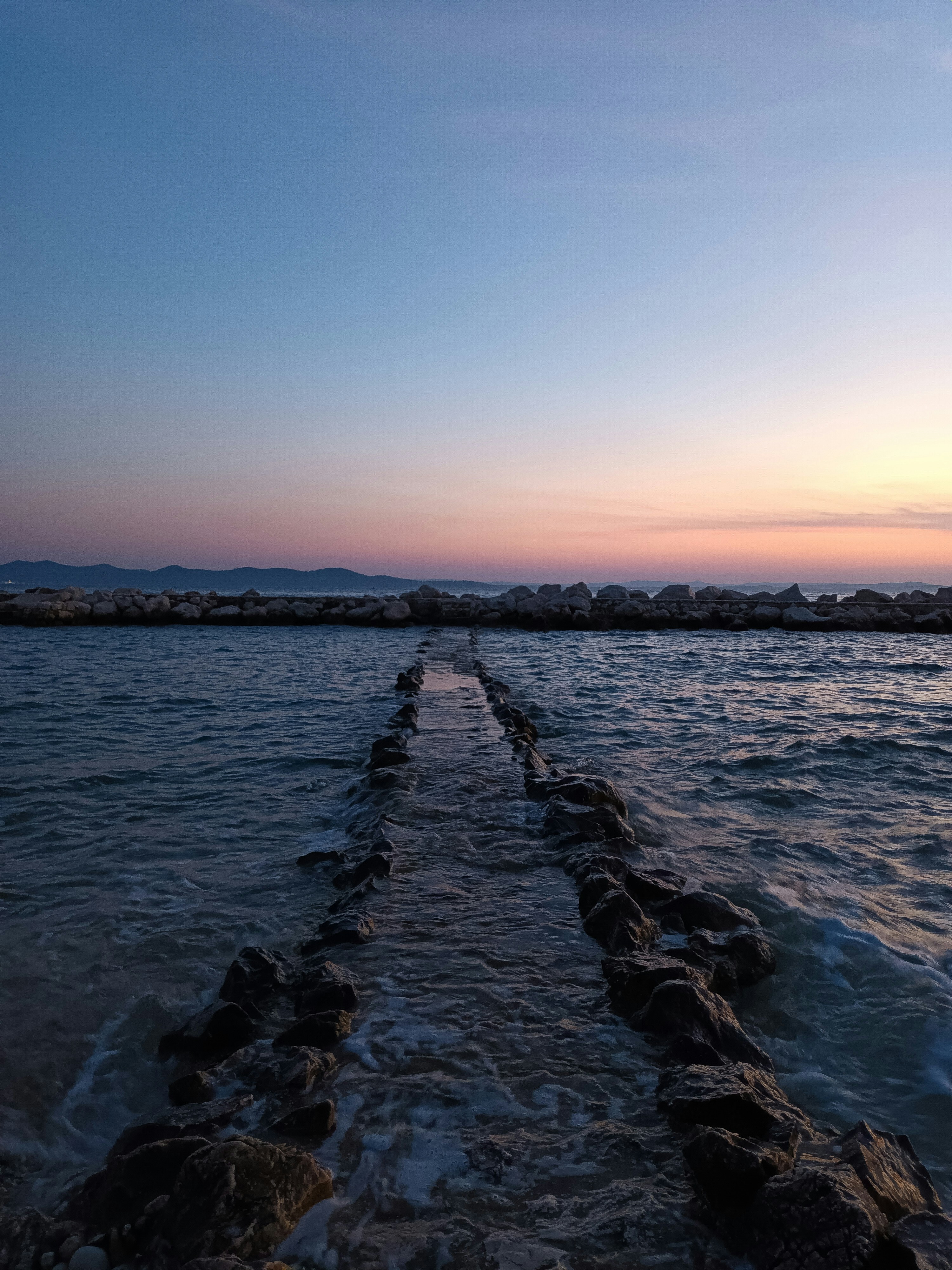 A view of the ocean from a pier at sunset