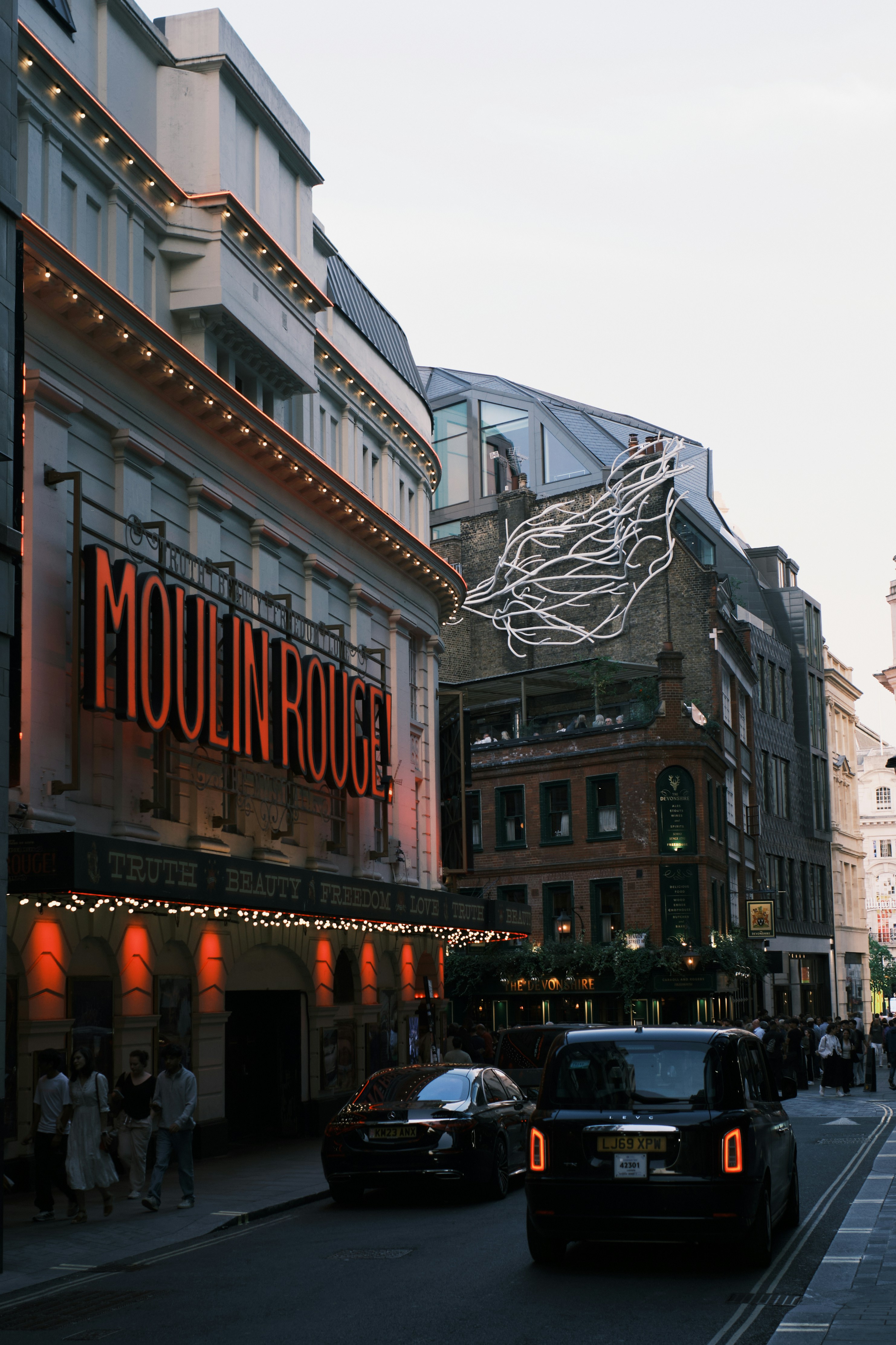 A city street with cars and people walking on the sidewalk photo – Free ...