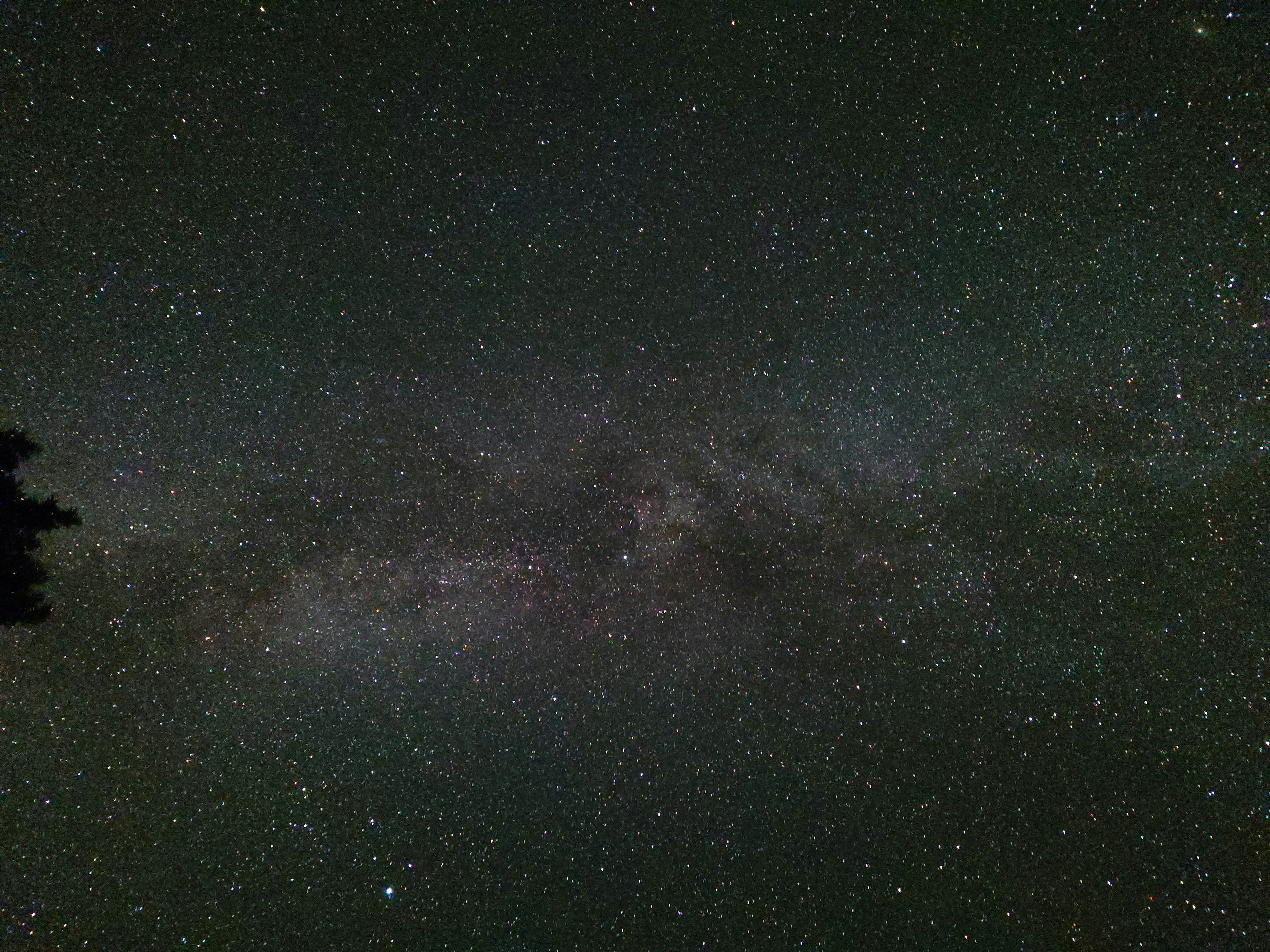 The Milky Way stretches across a star-filled night sky.