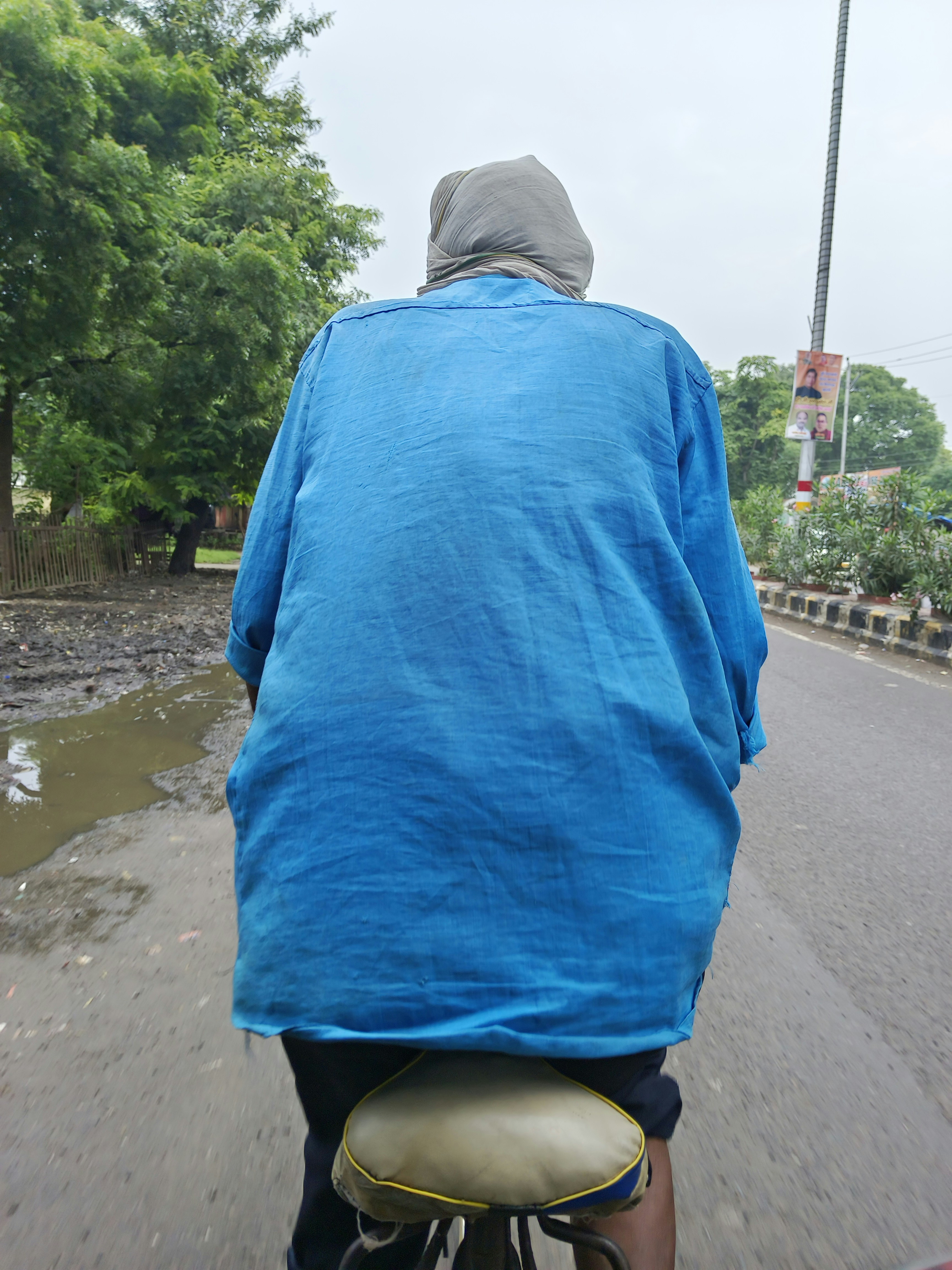 Azure Overgarment Rider on a Damp Suburban Road