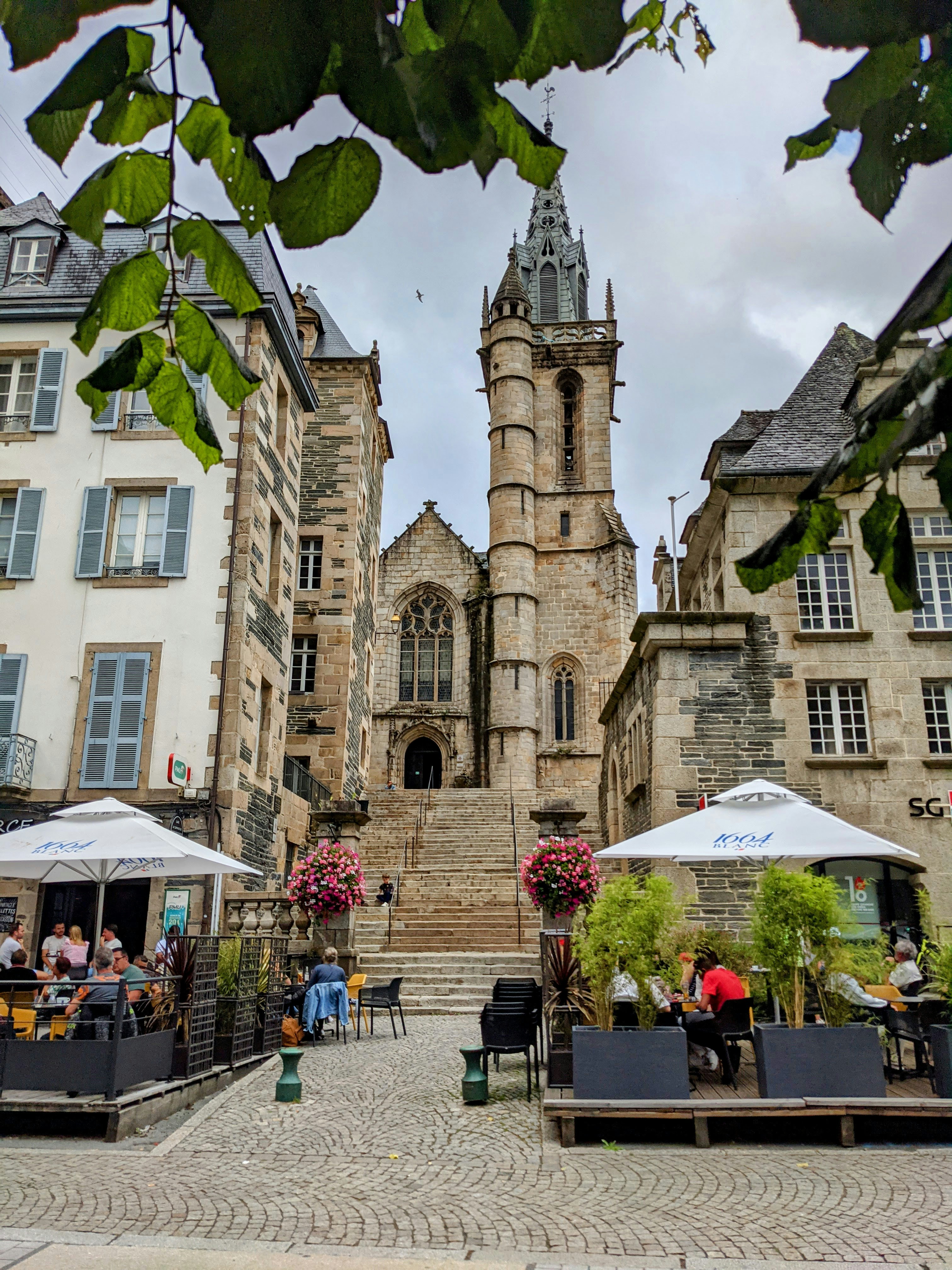 Towering Stone: A Cathedral Gate Rises Over a Café-Fringed Square