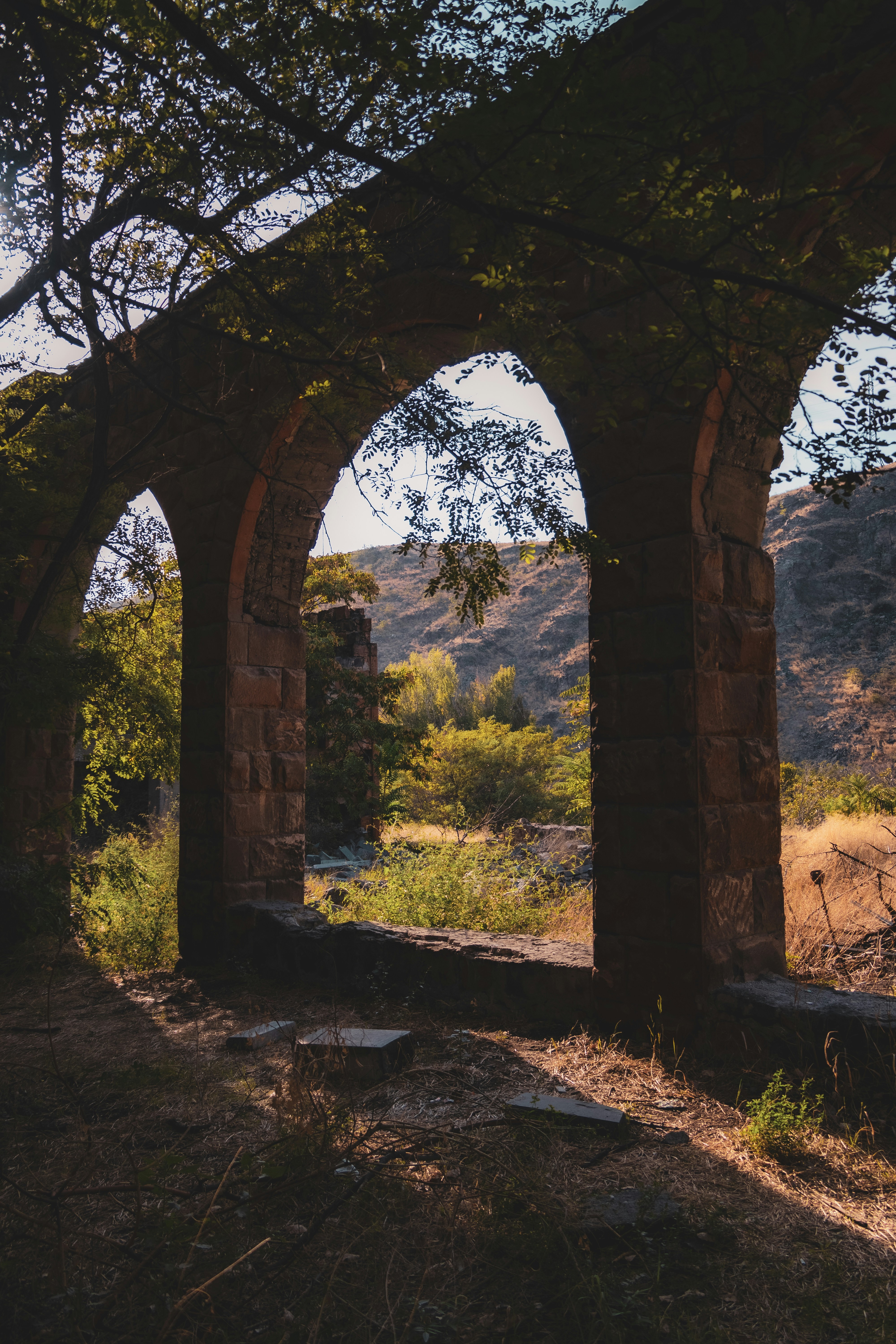 Stone Archway Framing a Sunlit Valley Beyond