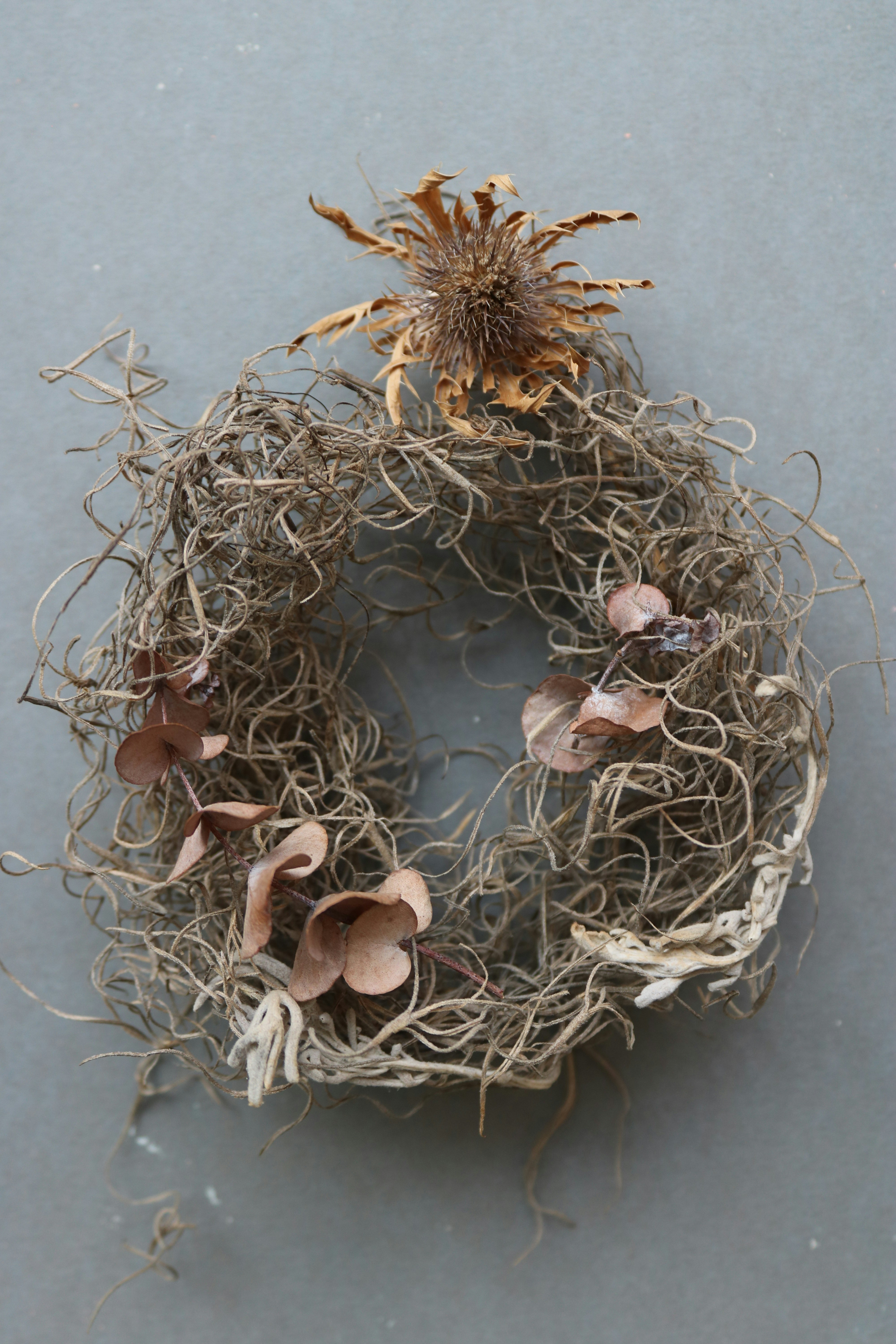 Withered Petal Wreath on a Muted Slate Surface