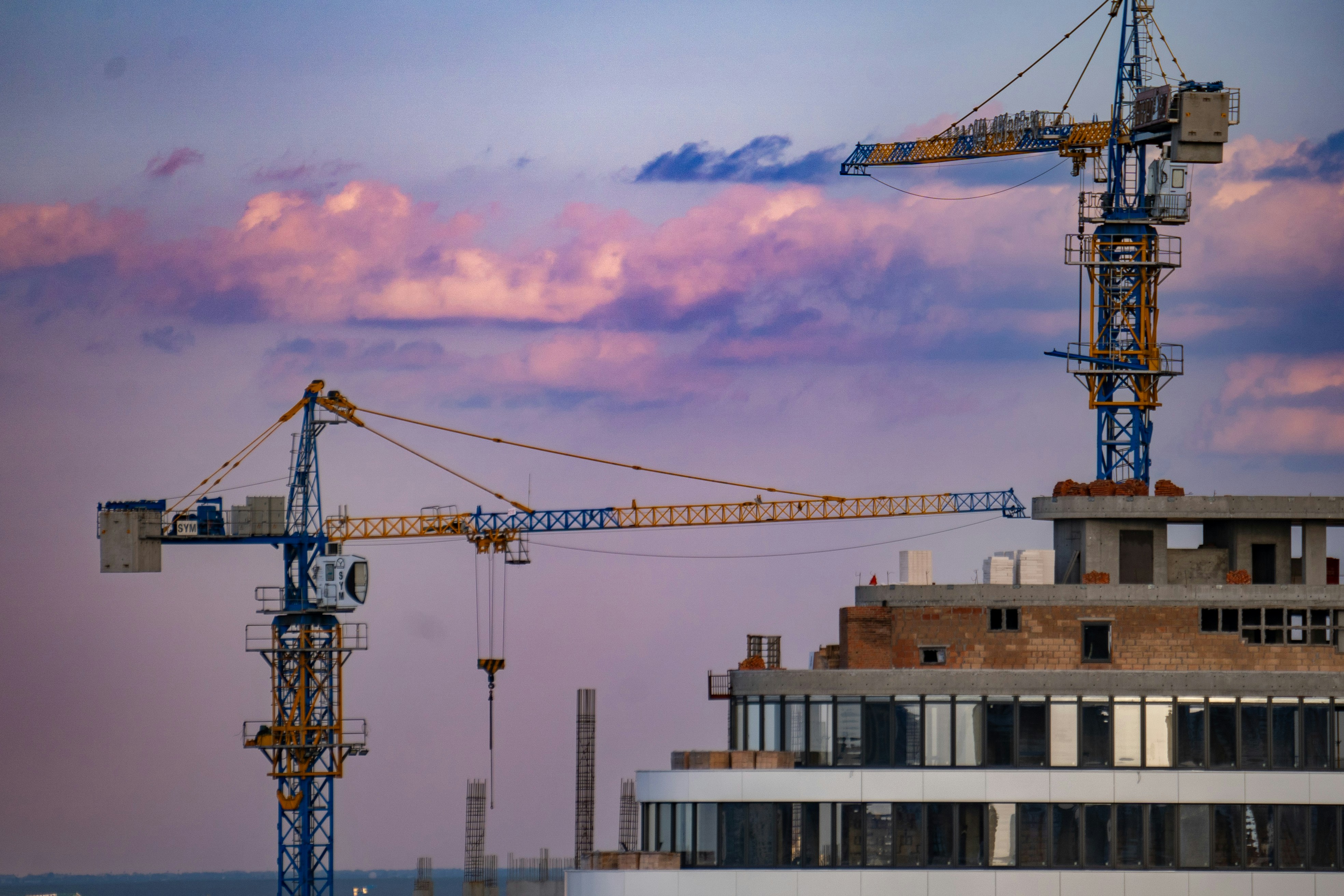 A large building with a crane on top of it photo – Free Construction ...