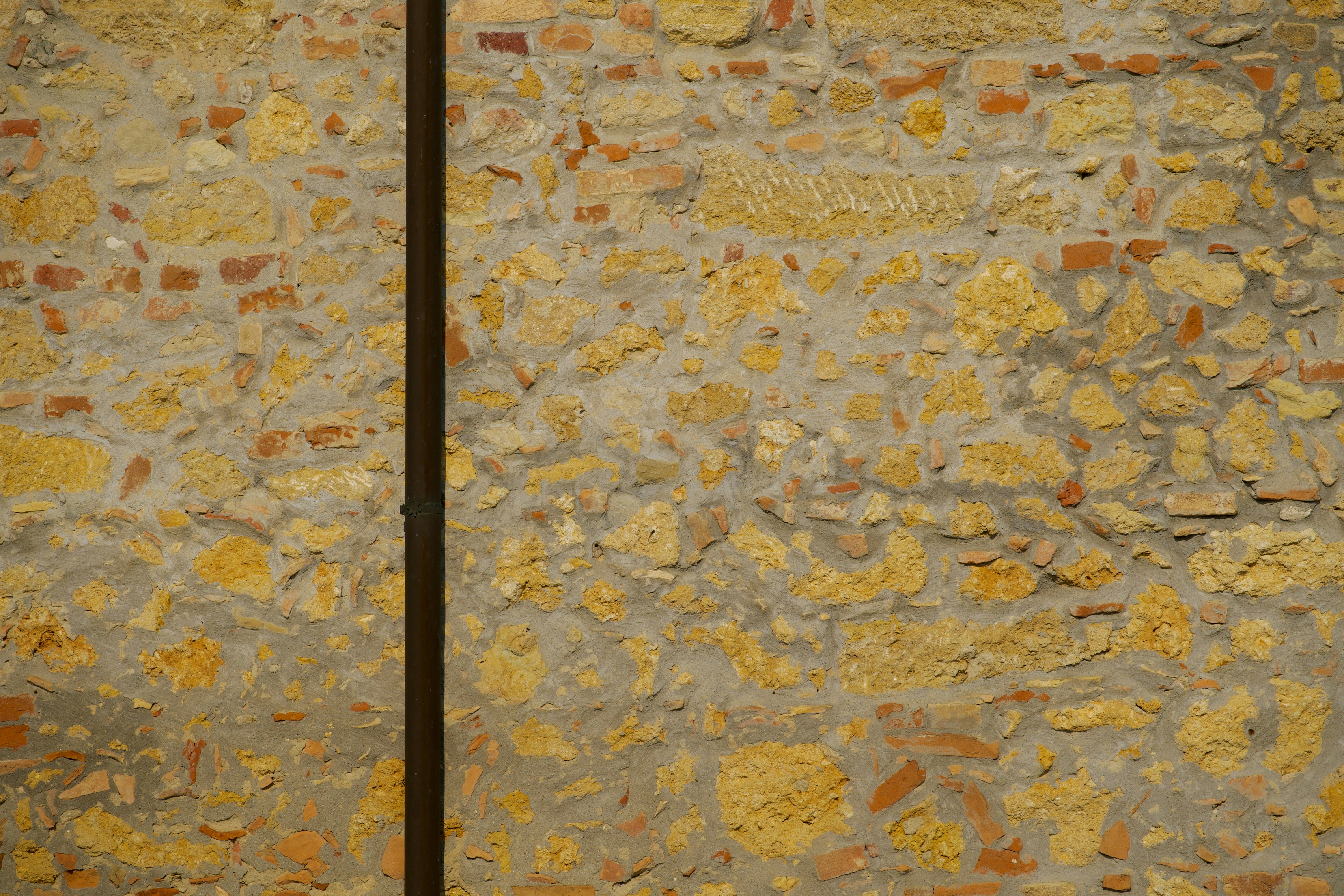 Sunlit Pebbles and a Dark Stripe: Textural Portrait of a Rustic Stone Wall