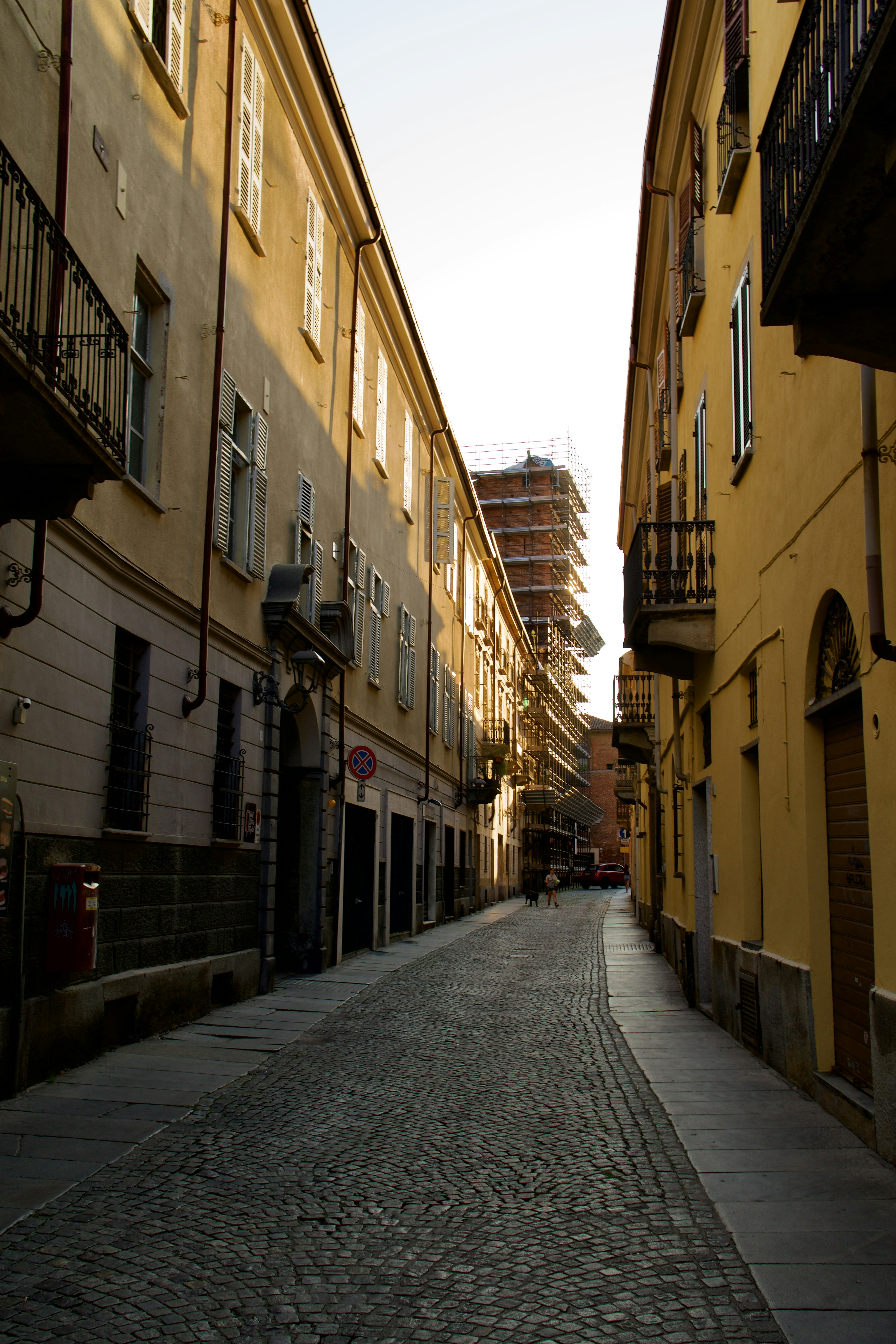 A narrow city street lined with tall buildings photo – Free Car Image ...