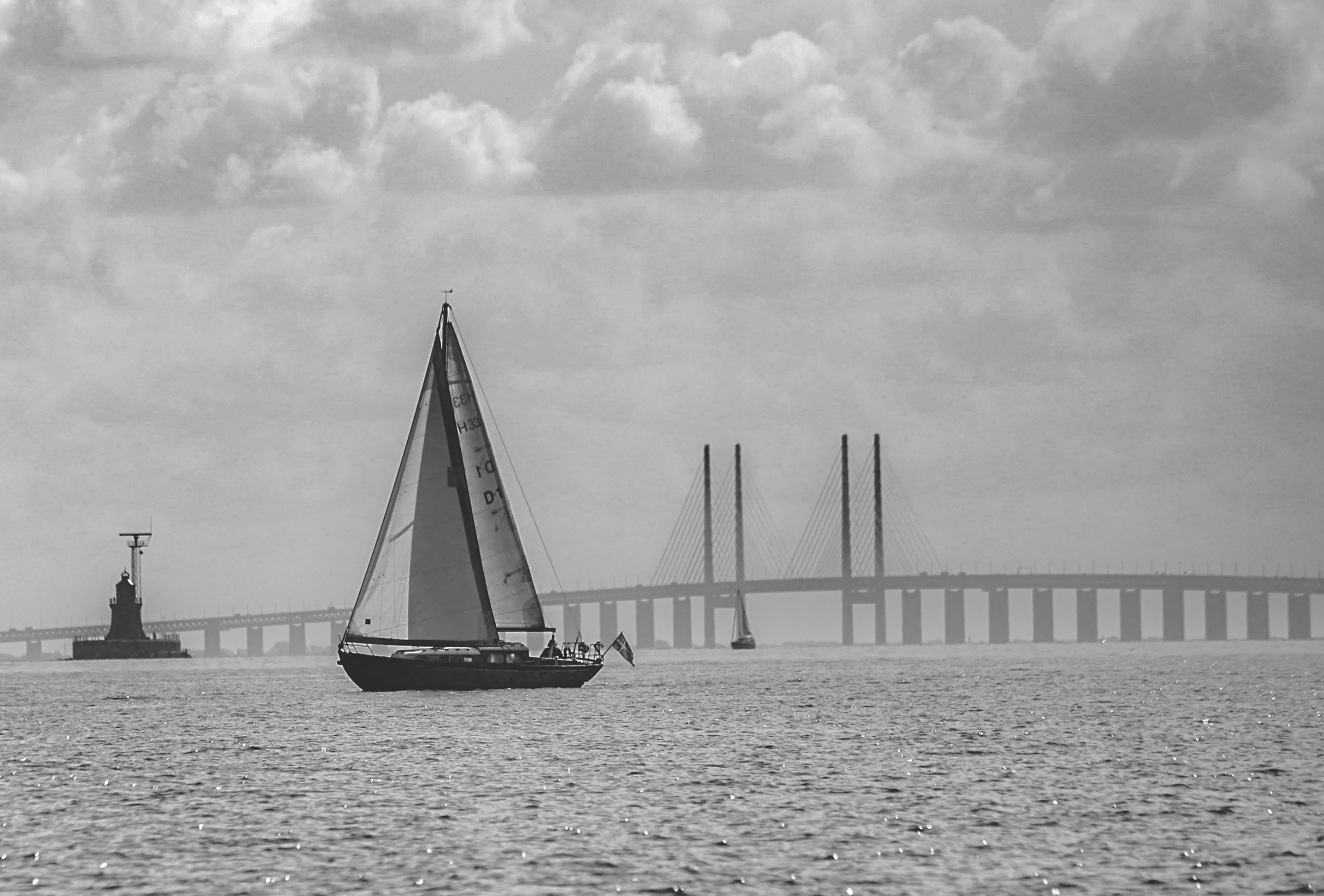 Grey Tides: A Sailboat Pierces the Silence of the Distant Span