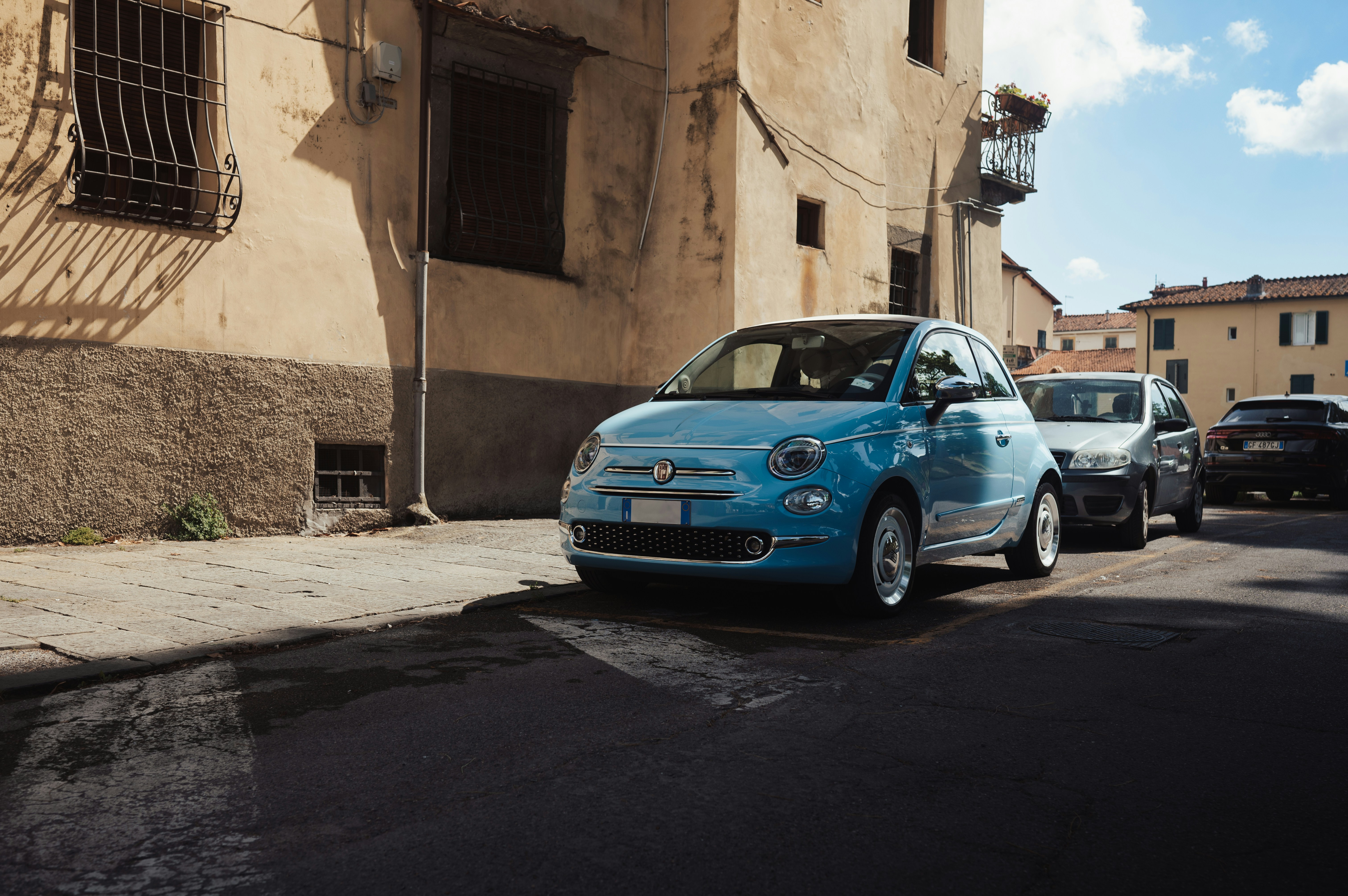 Sunlit Blue Fiat 500 Anchors a Quiet Italian Street