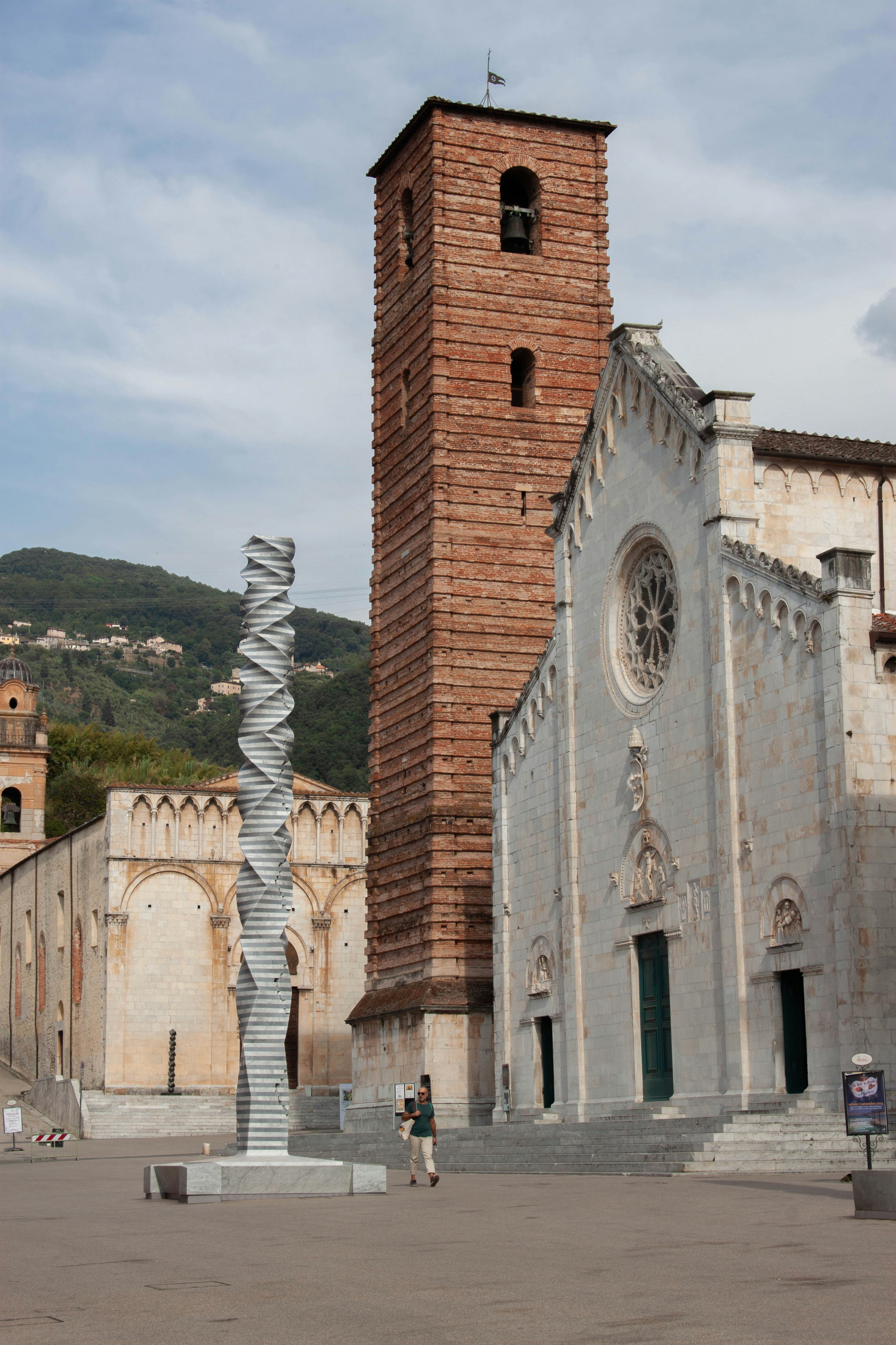 Towering Brick Bell Tower beside a Pale Church Facade in an Italian Square
