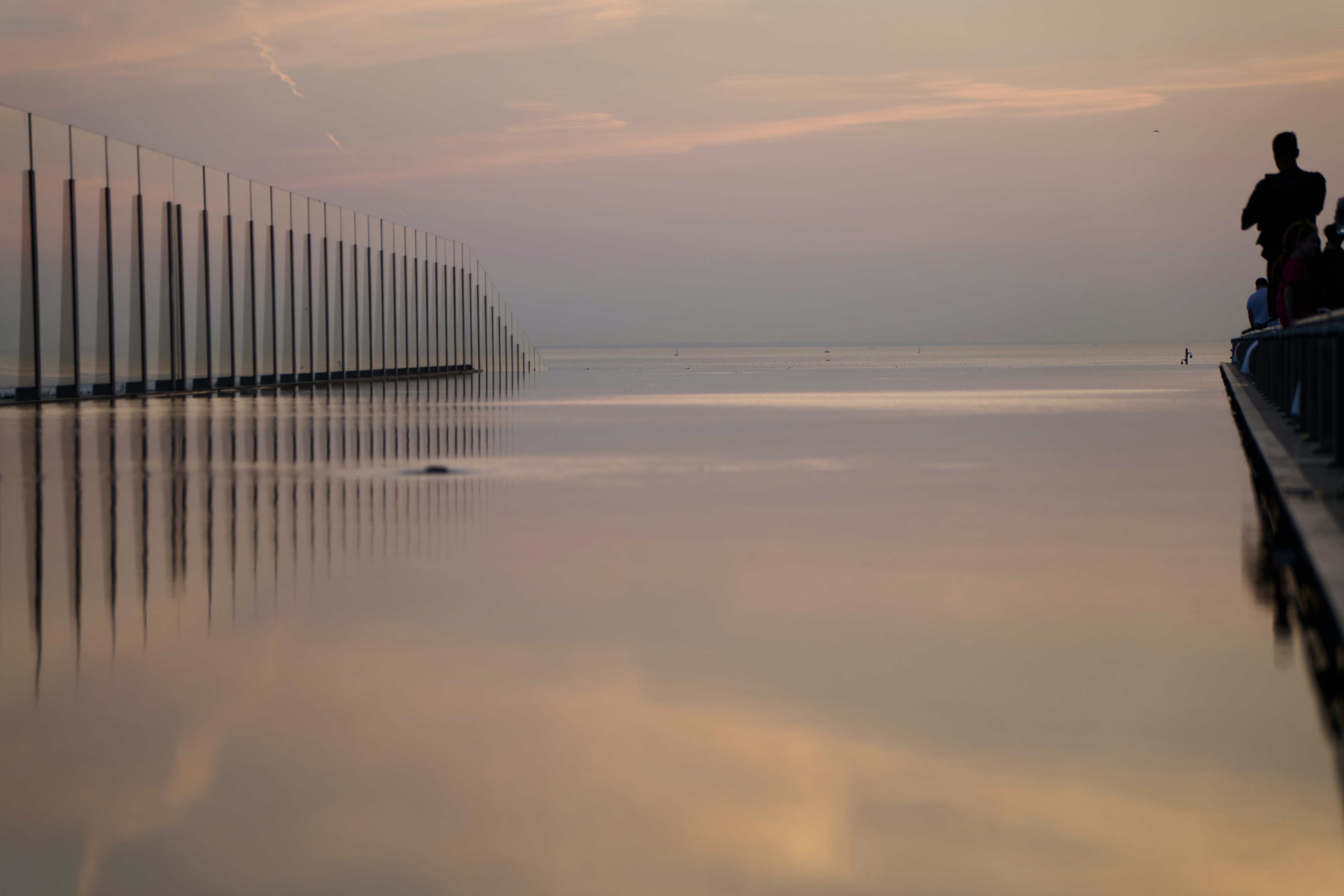 Dusk on the Glassy Jetty: Silhouettes and Reflections