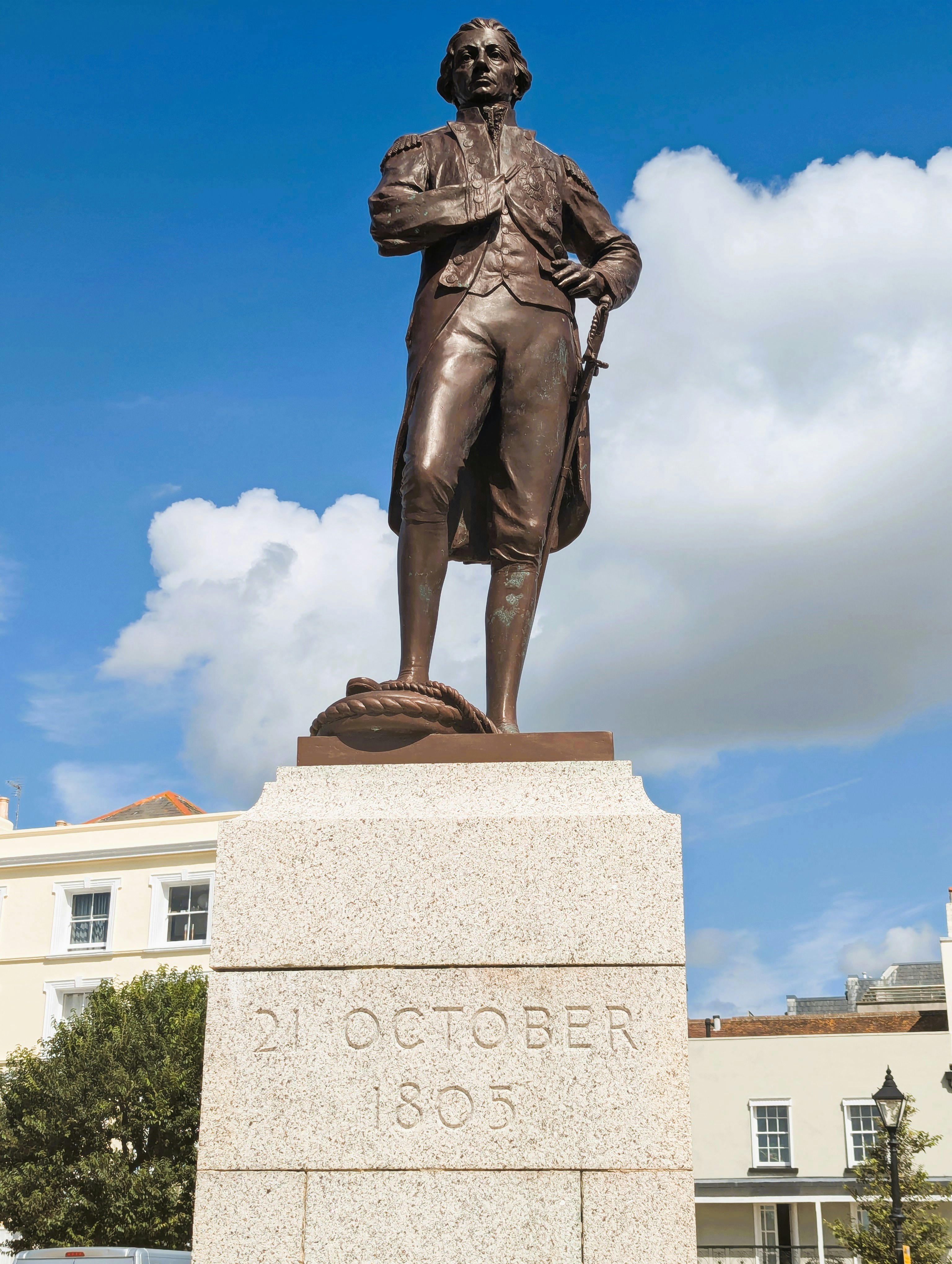 Bronze Statue of a Historic Leader Rising Over a Sunlit Town Square